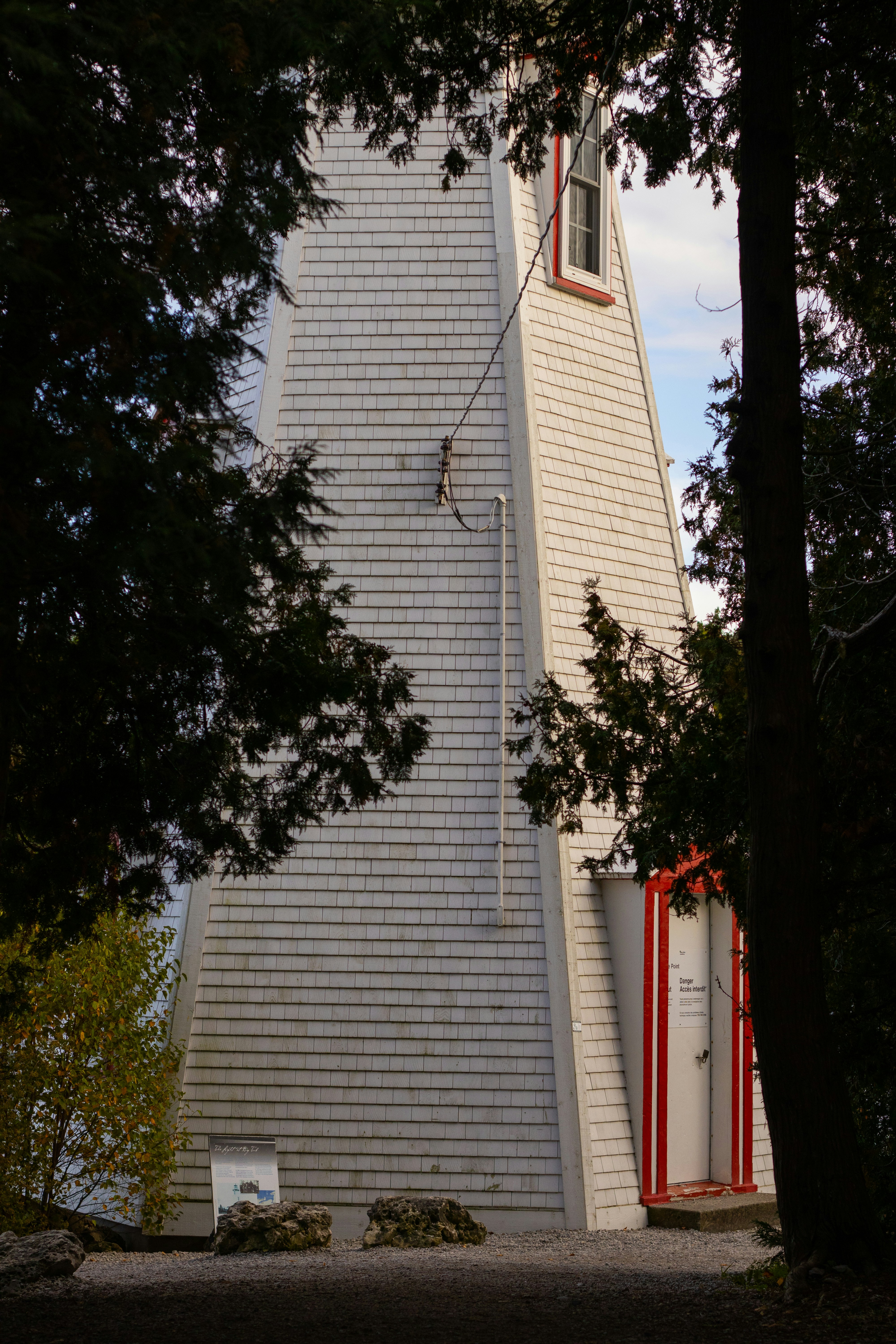 The Big Tub Lighthouse at Tobermory during a fall sunset peeks through the woods.