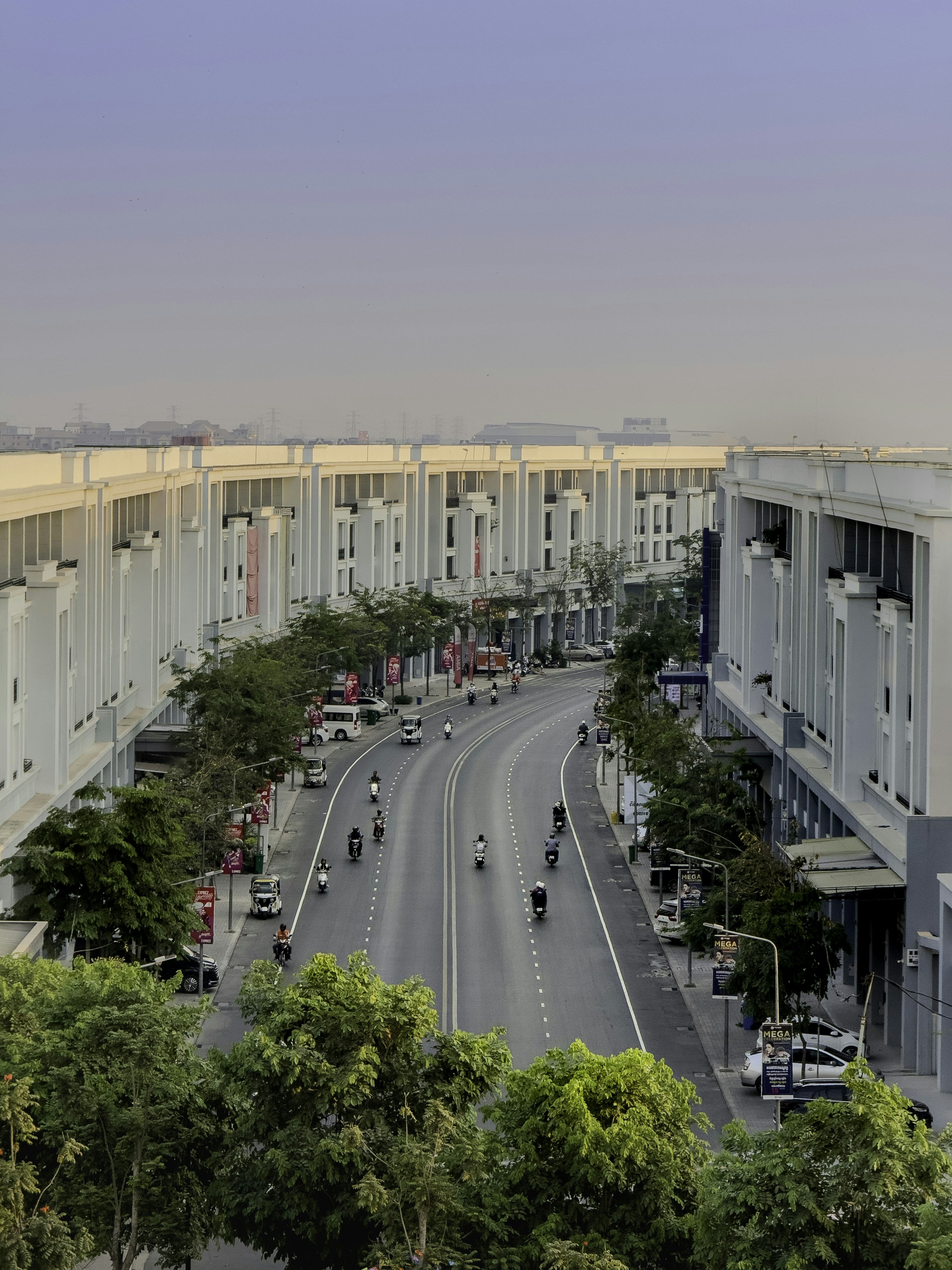 Sunset Corridor: Aerial View of a City Street Framed by White Arcades