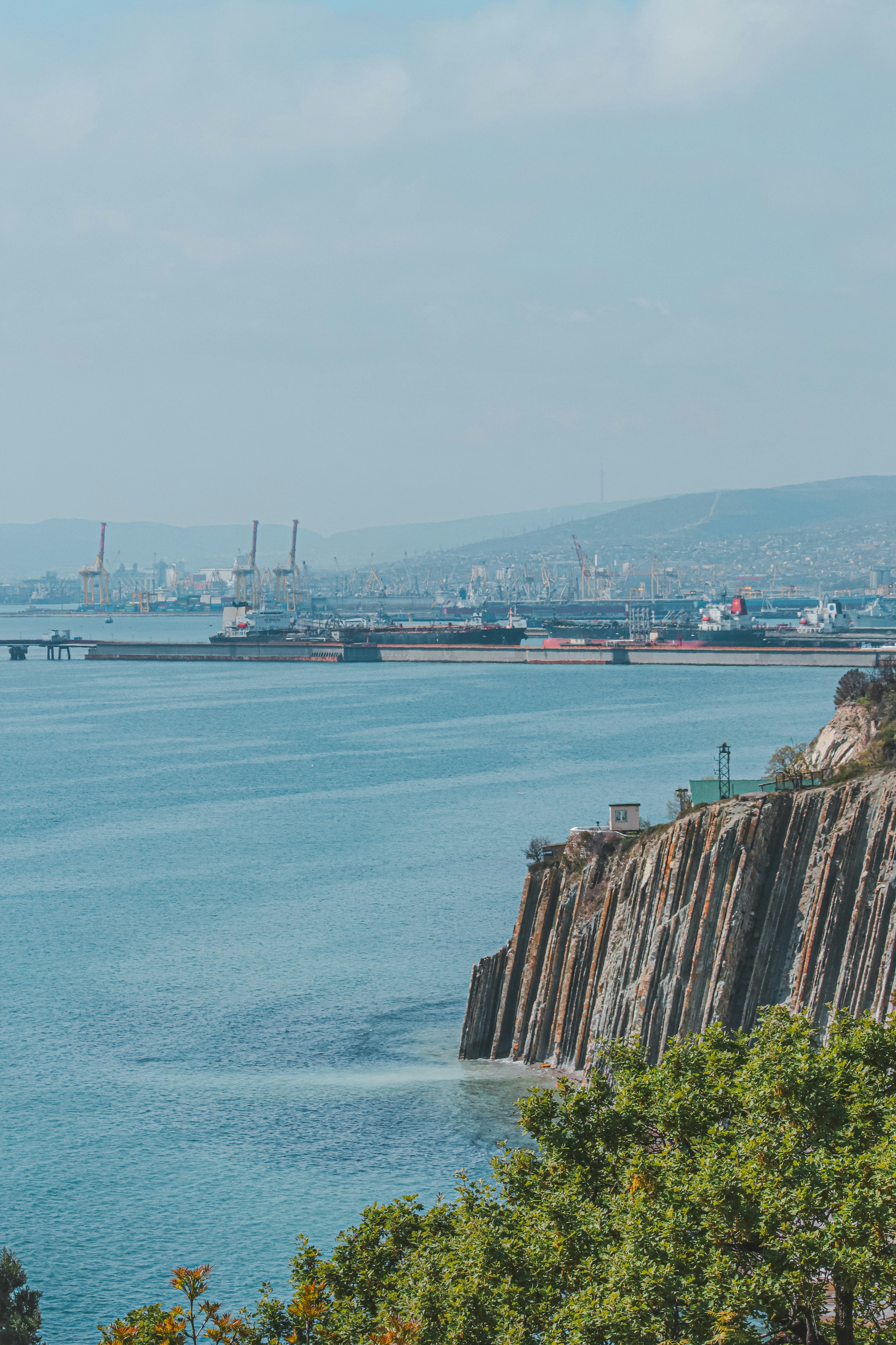 Cliffside Shoreline with Industrial Harbor in the Distance