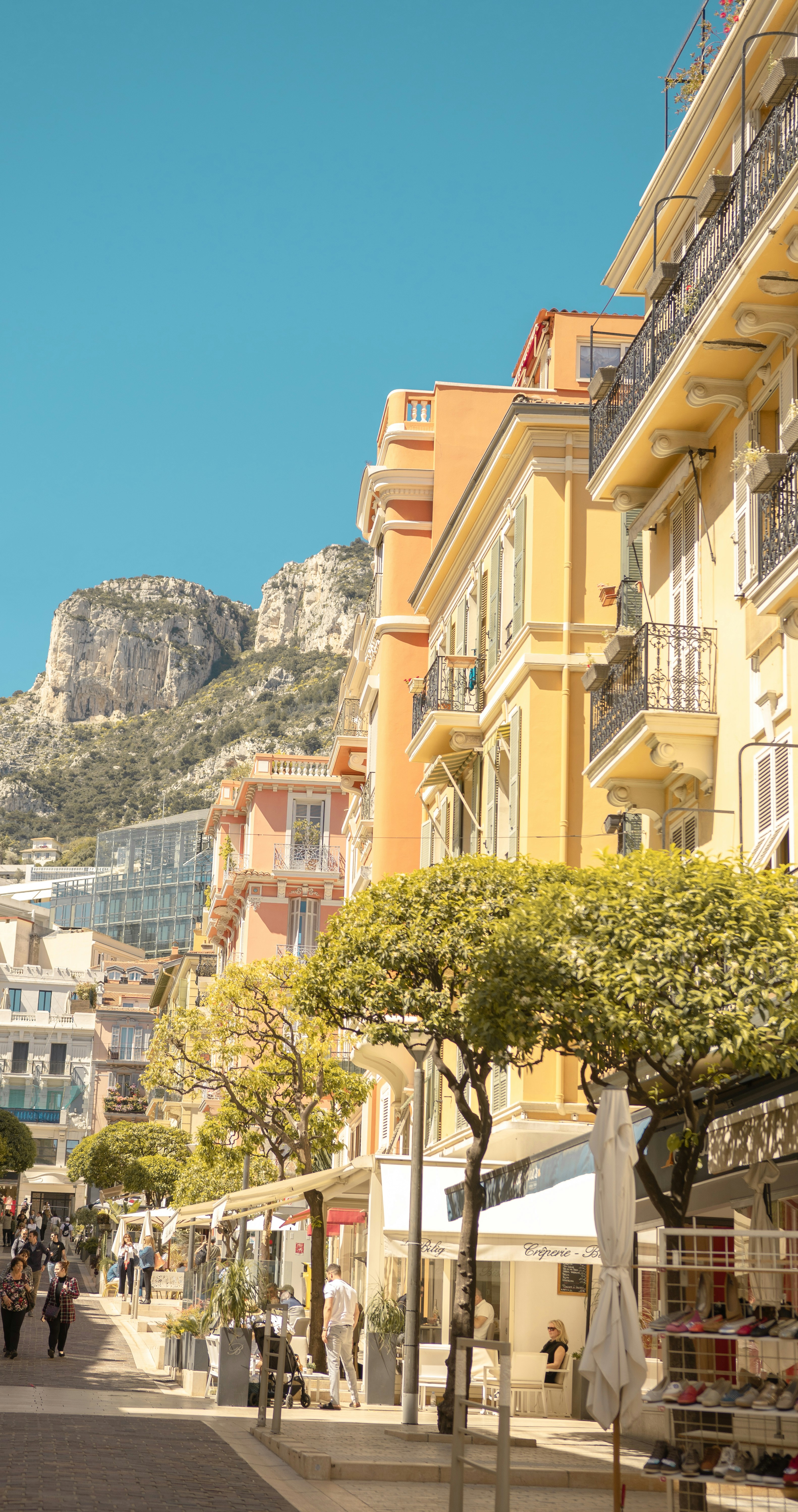 A group of people walking down a street next to tall buildings photo ...