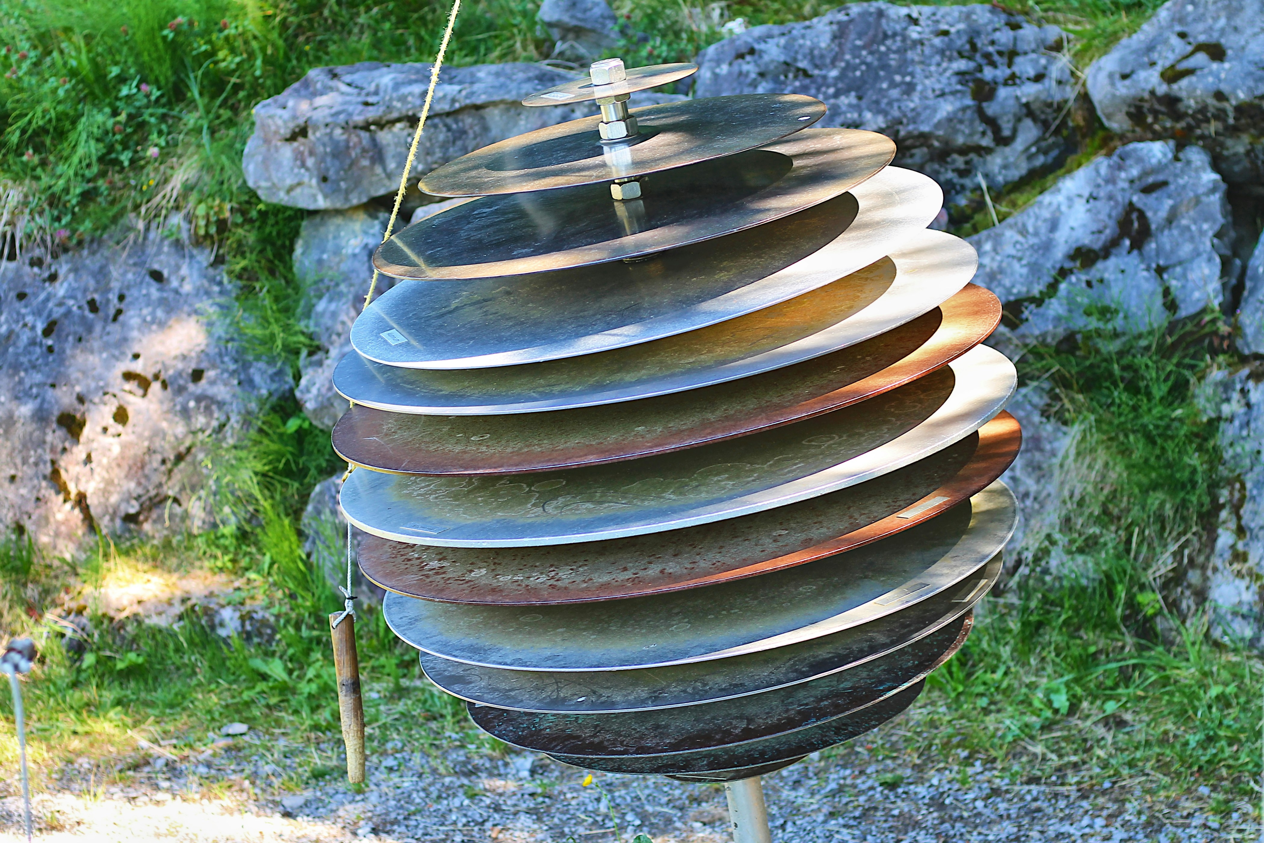 Spinning Disc Mosaic: A Colorful Array of Plates in a Garden Well