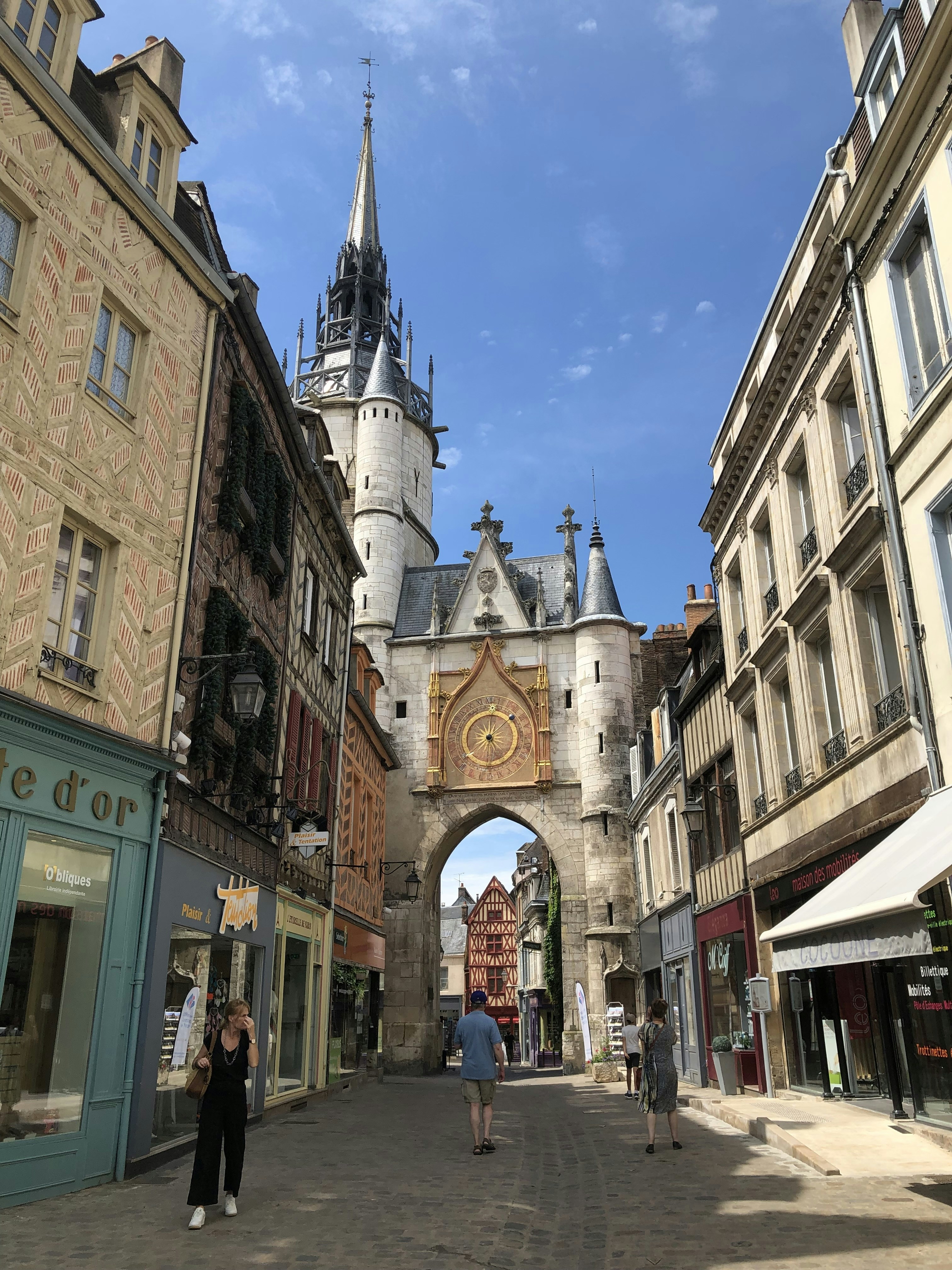 Cobblestone Street to a Clock-Tower Gate Under a Clear Blue Sky