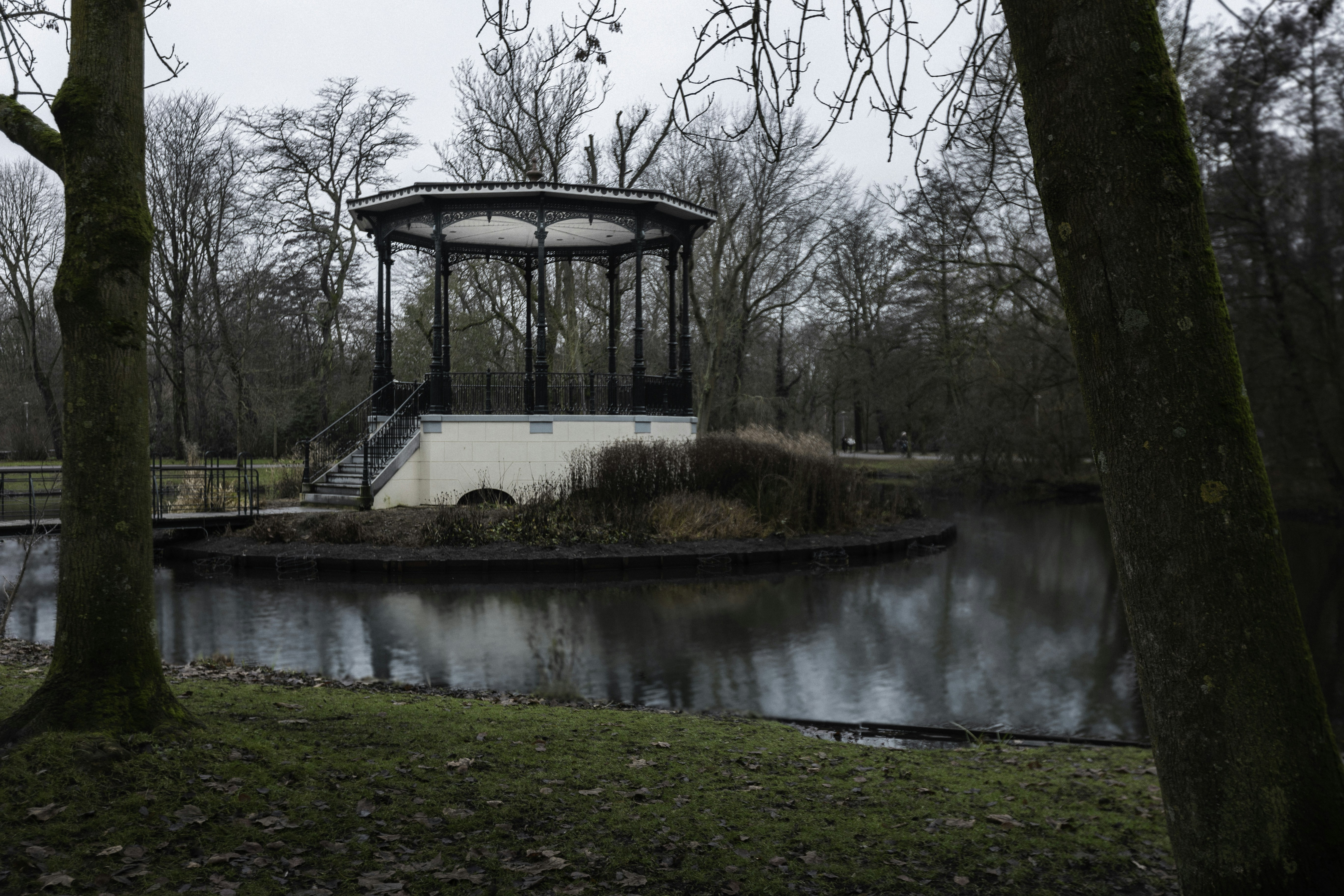 A Serene Lake Gazebo Framed by Bare Trees in Early Spring