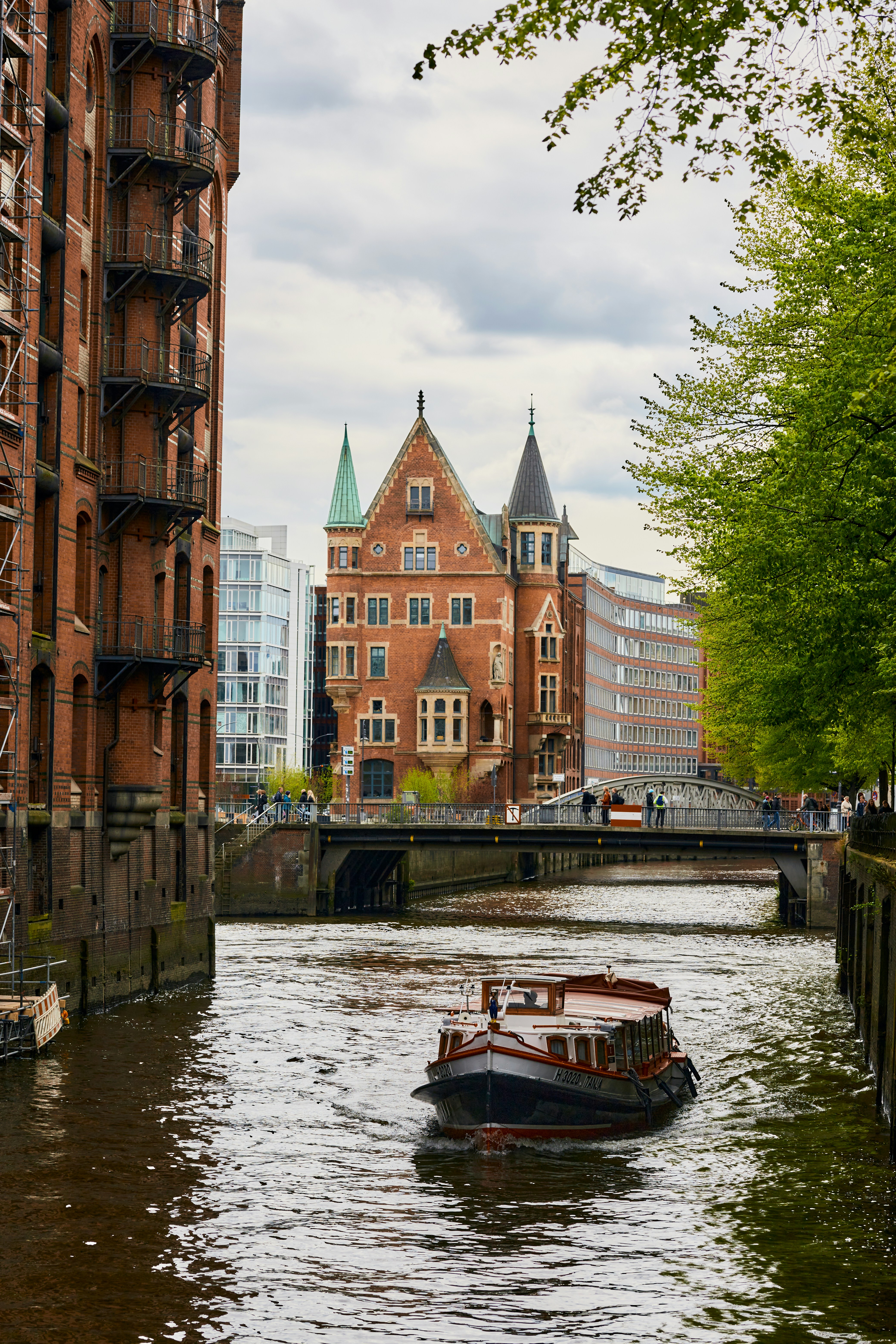 A boat traveling down a river next to tall buildings photo – Free ...