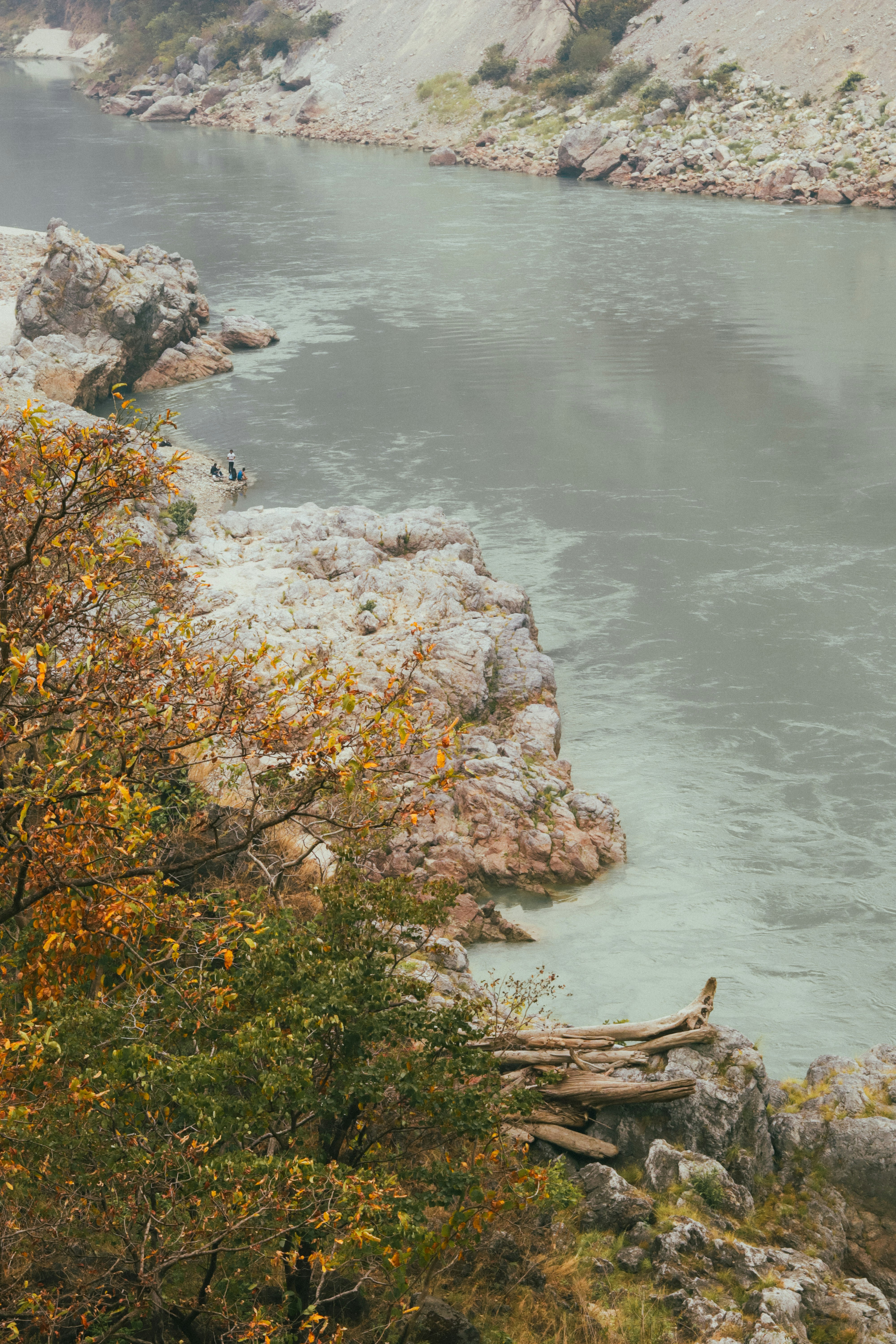 Autumn Edge: Turquoise River Winding Between Cliffside Stones