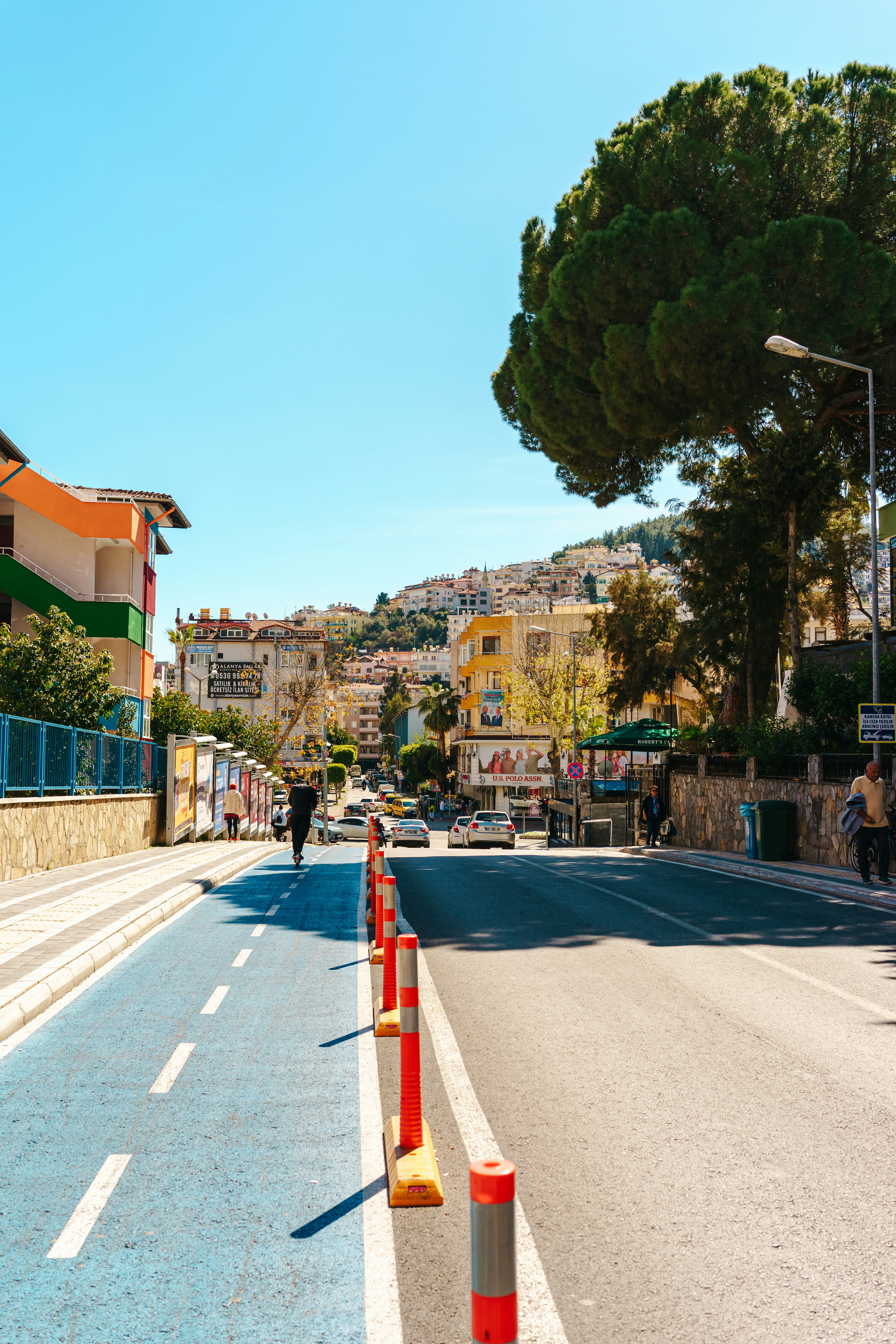Coned Corridor: A Sun-Drenched Street Toward a Hillside Town