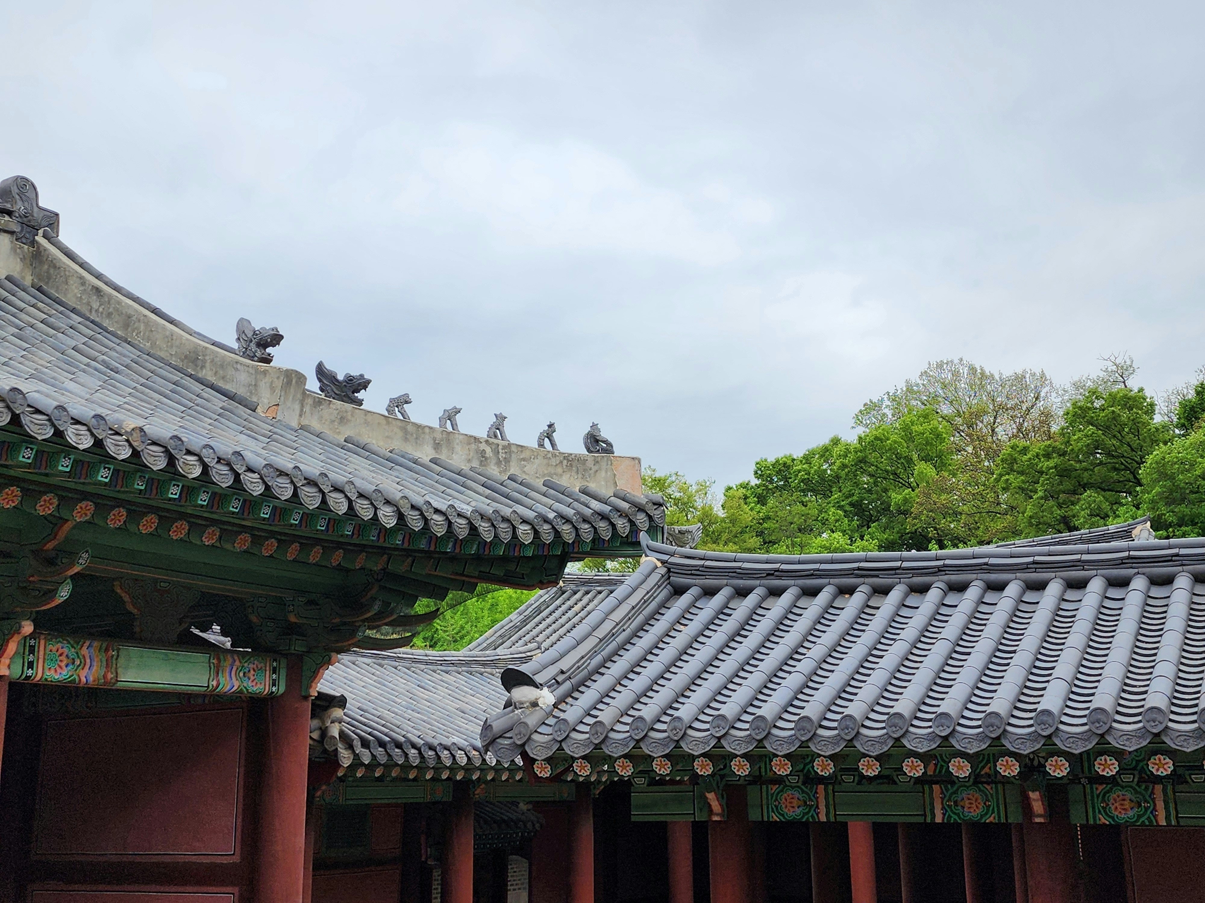 Ridgeline Guardians: Fine-Toned Tiles and Dragoncrest Figures on a Temple Roof