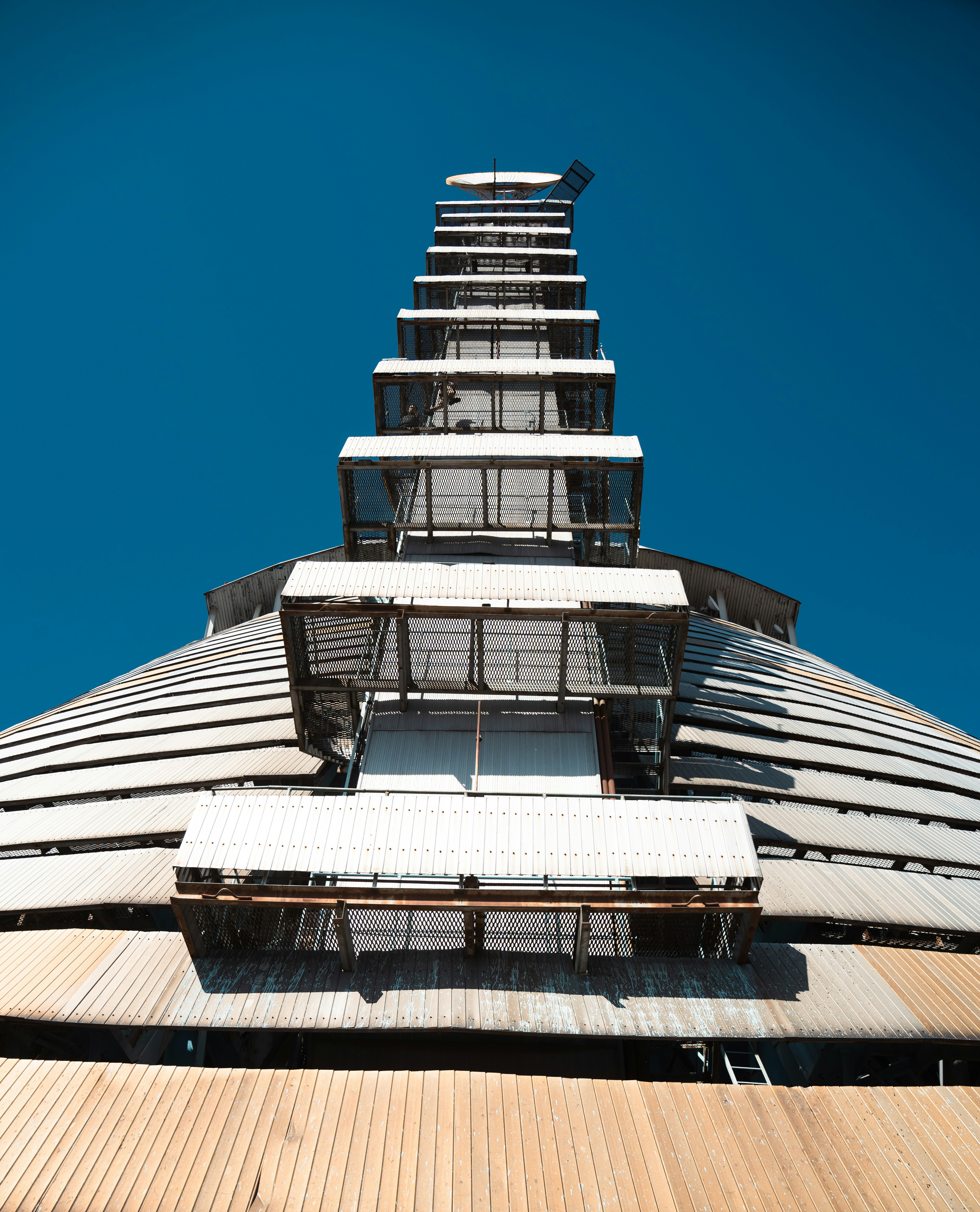 Vertical Stack: A Rusted Platform Tower Pierces the Cerulean Sky