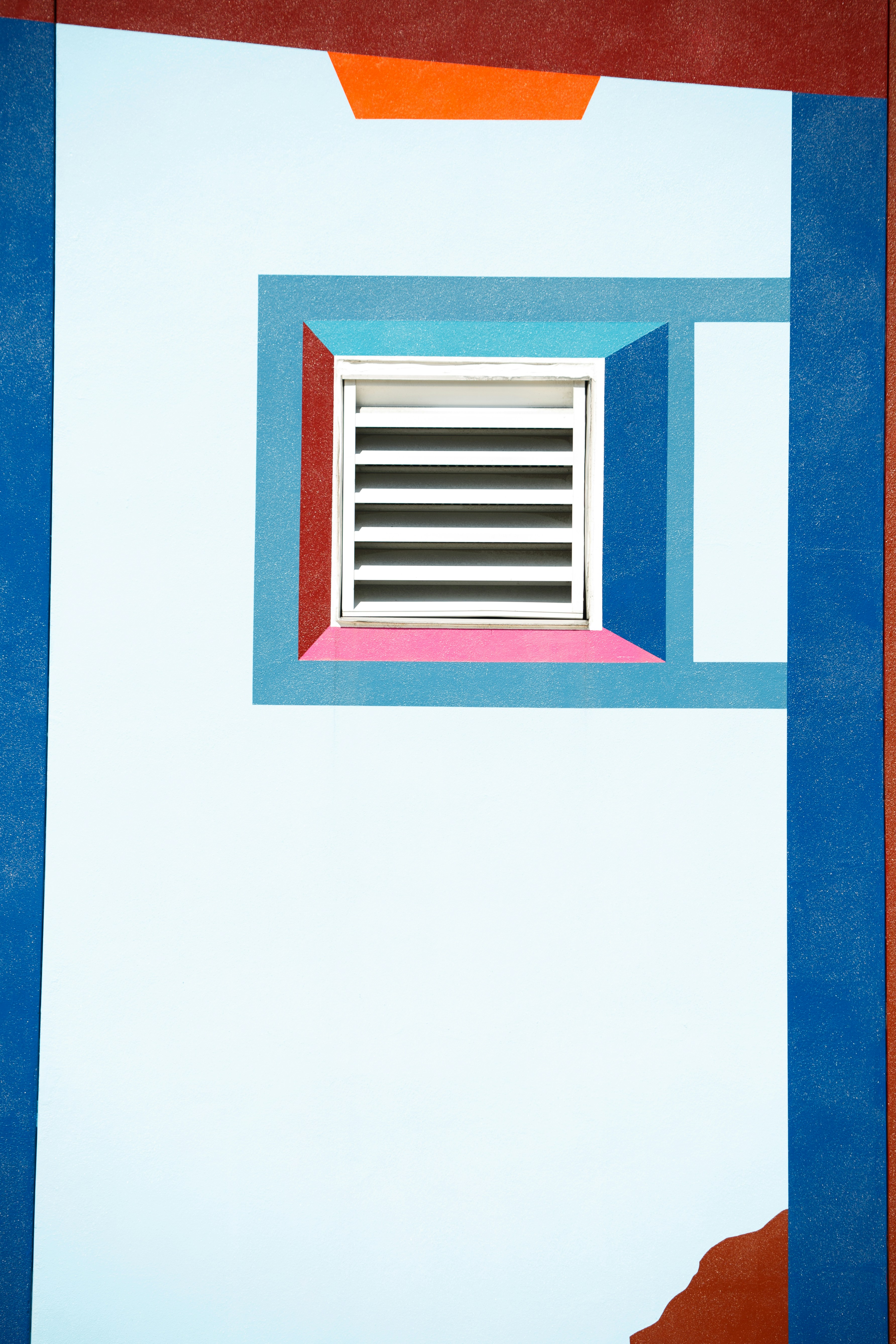 Centered in Color: A vented window nested in a geometric mural