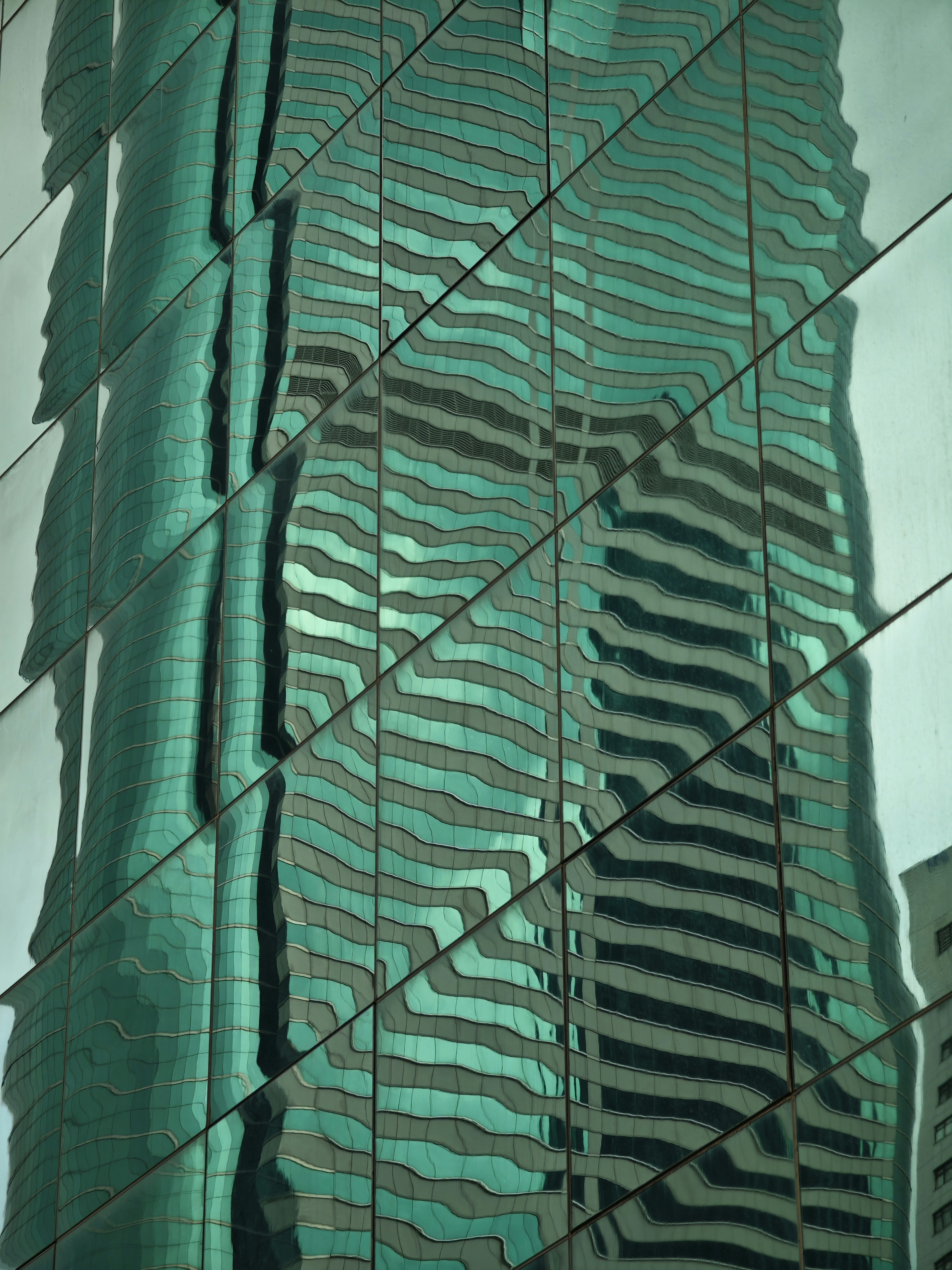 The building across the street reflected in the glass curtain wall.