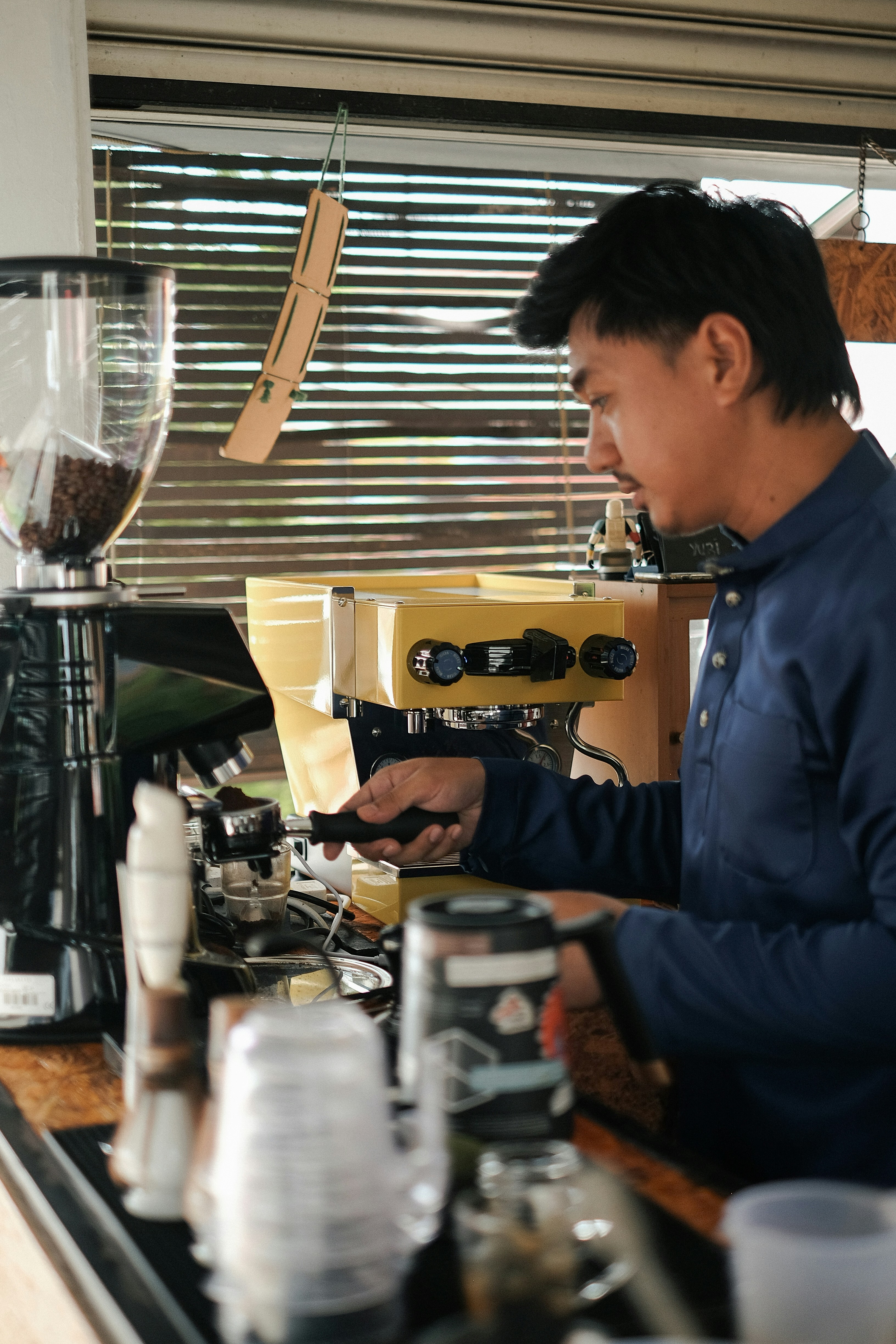 Brewing Precision: Barista Hands at the Portafilter in a Busy Café