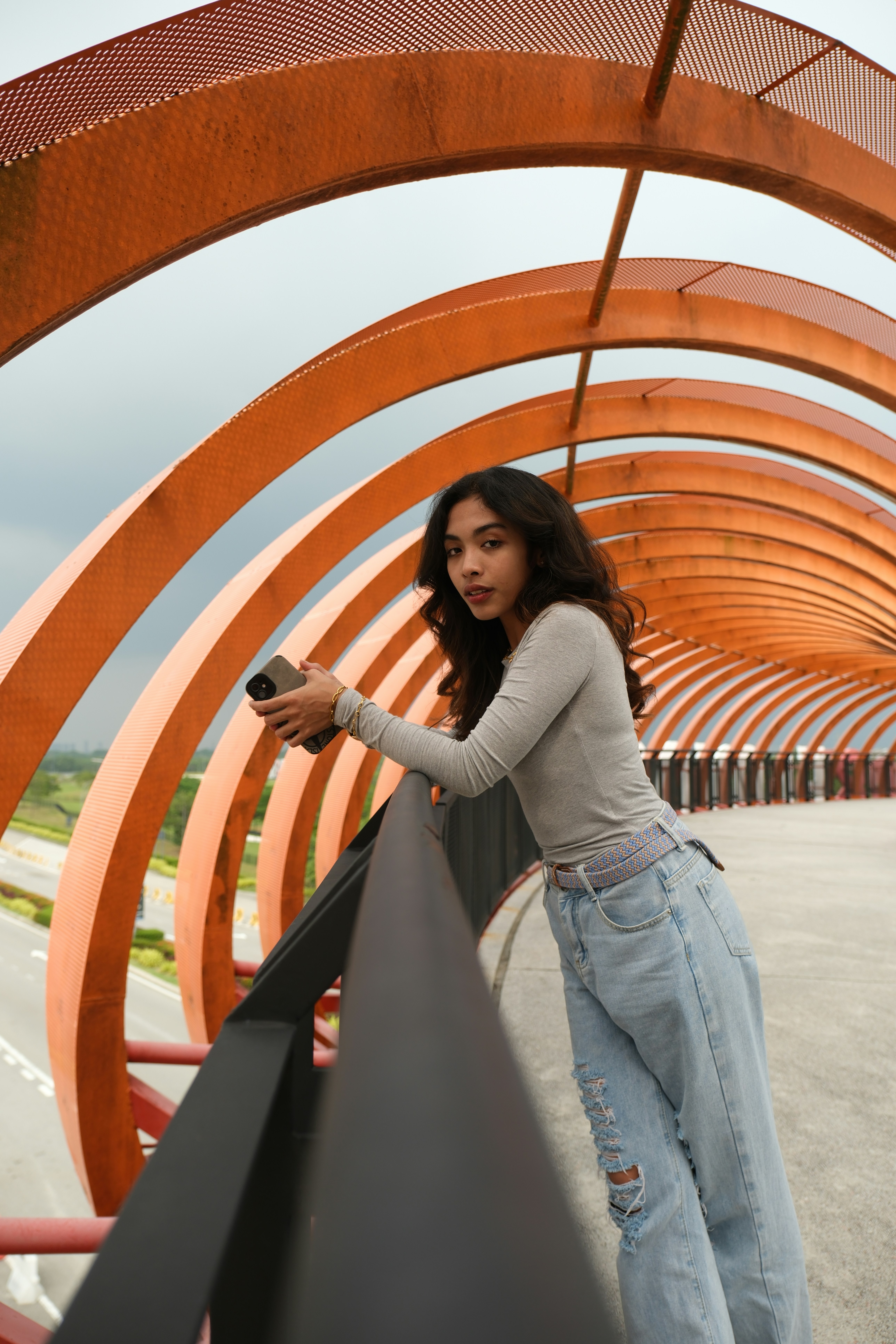 Curved Corridor Portrait: A Quiet Moment on the Orange Arc Walkway