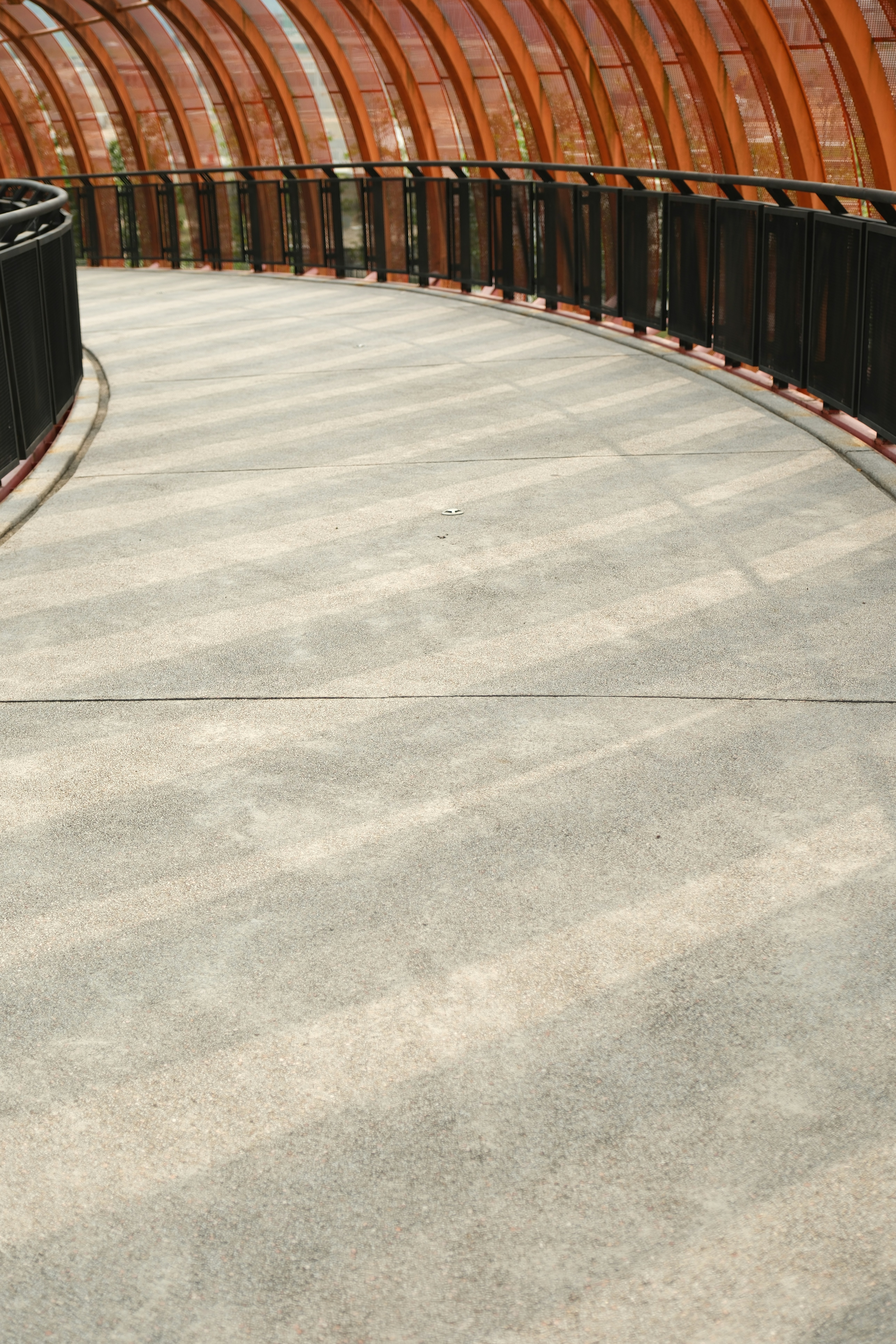 Curved pedestrian promenade under an amber skylight