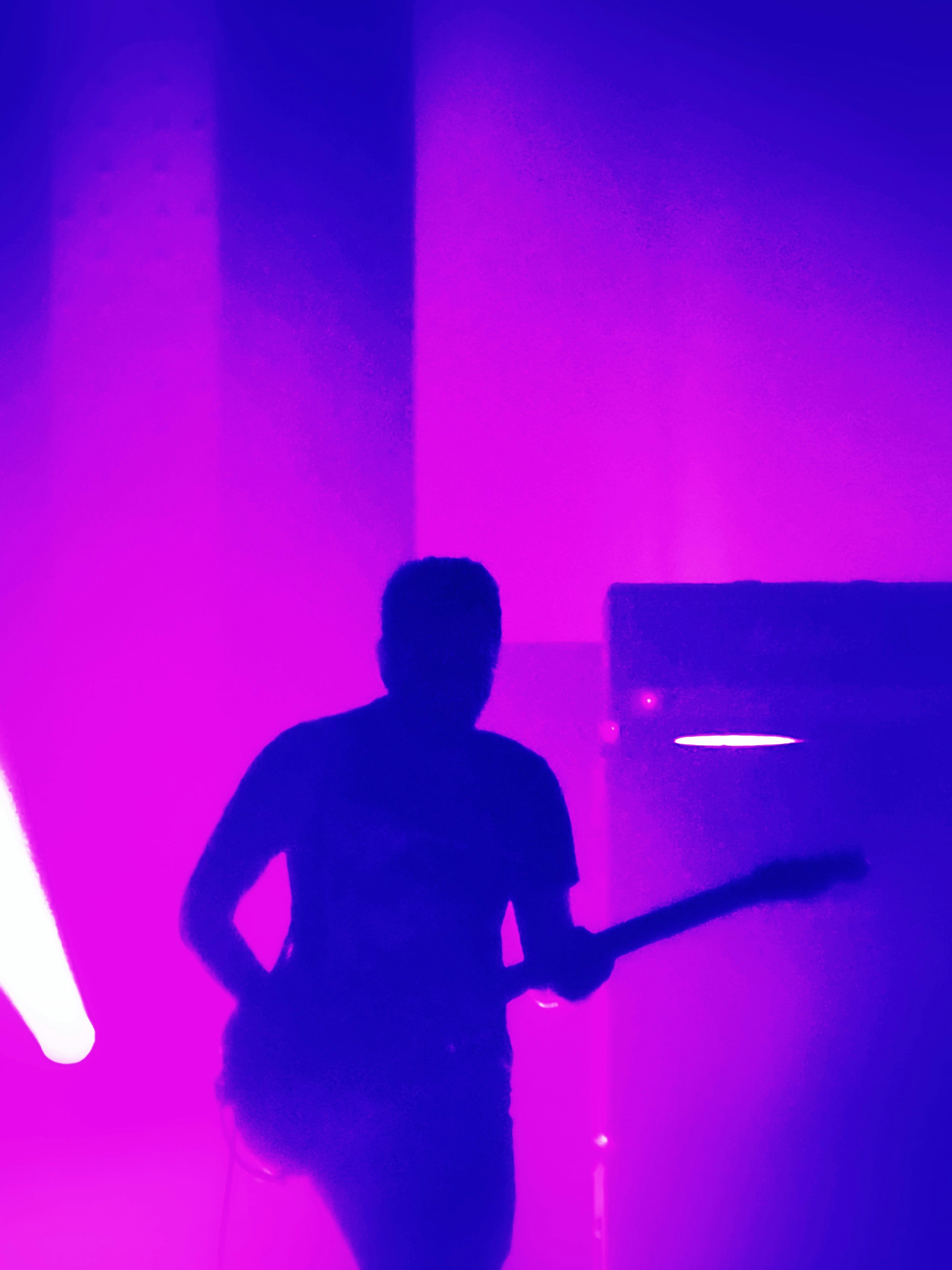 Silhouette on Neon Stages: Guitarist in Violet-Glow
