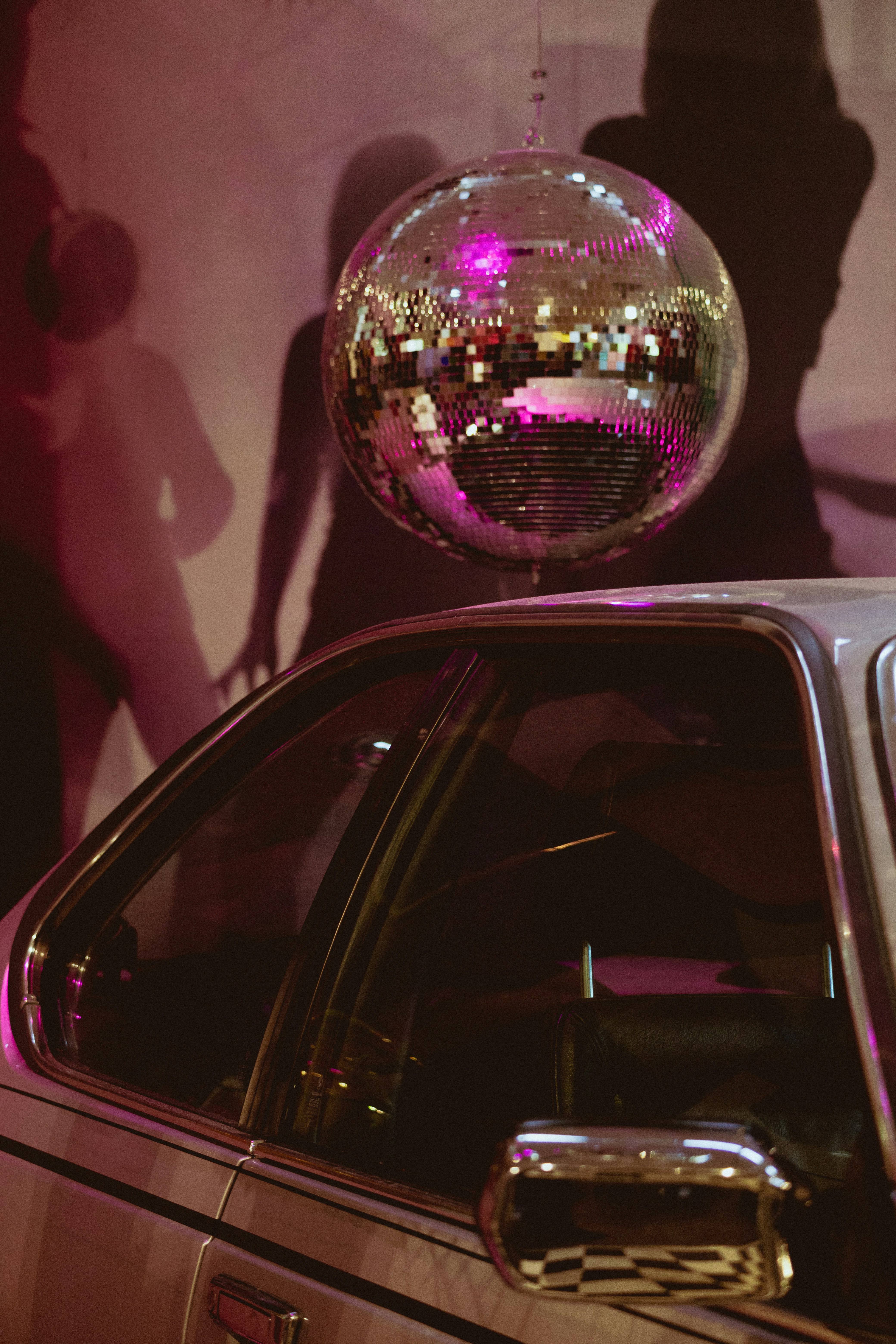 Magenta Mirage: A disco ball hovering above a vintage car