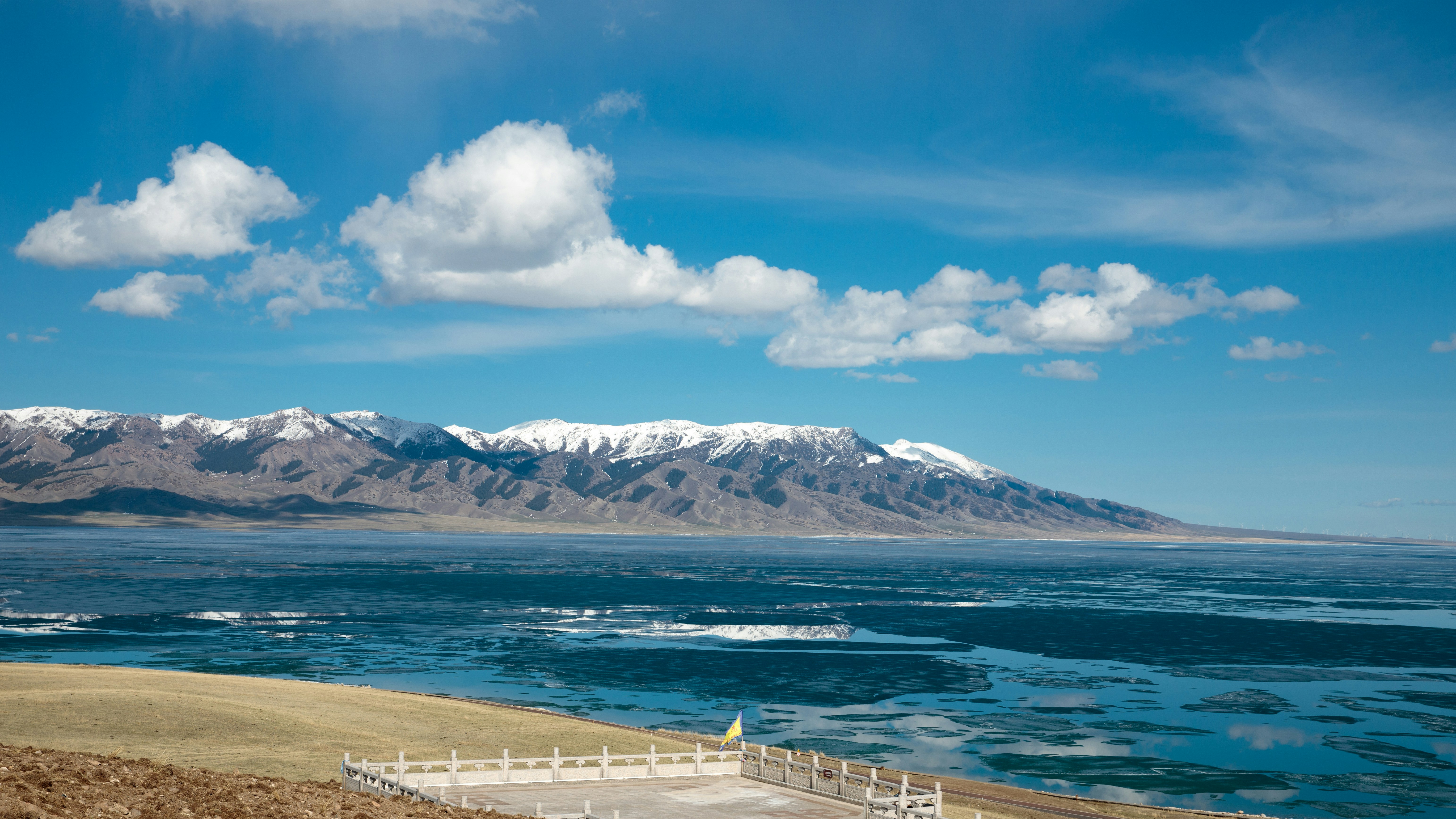 Snow-kissed Peaks Over a Quiet Azure Sea