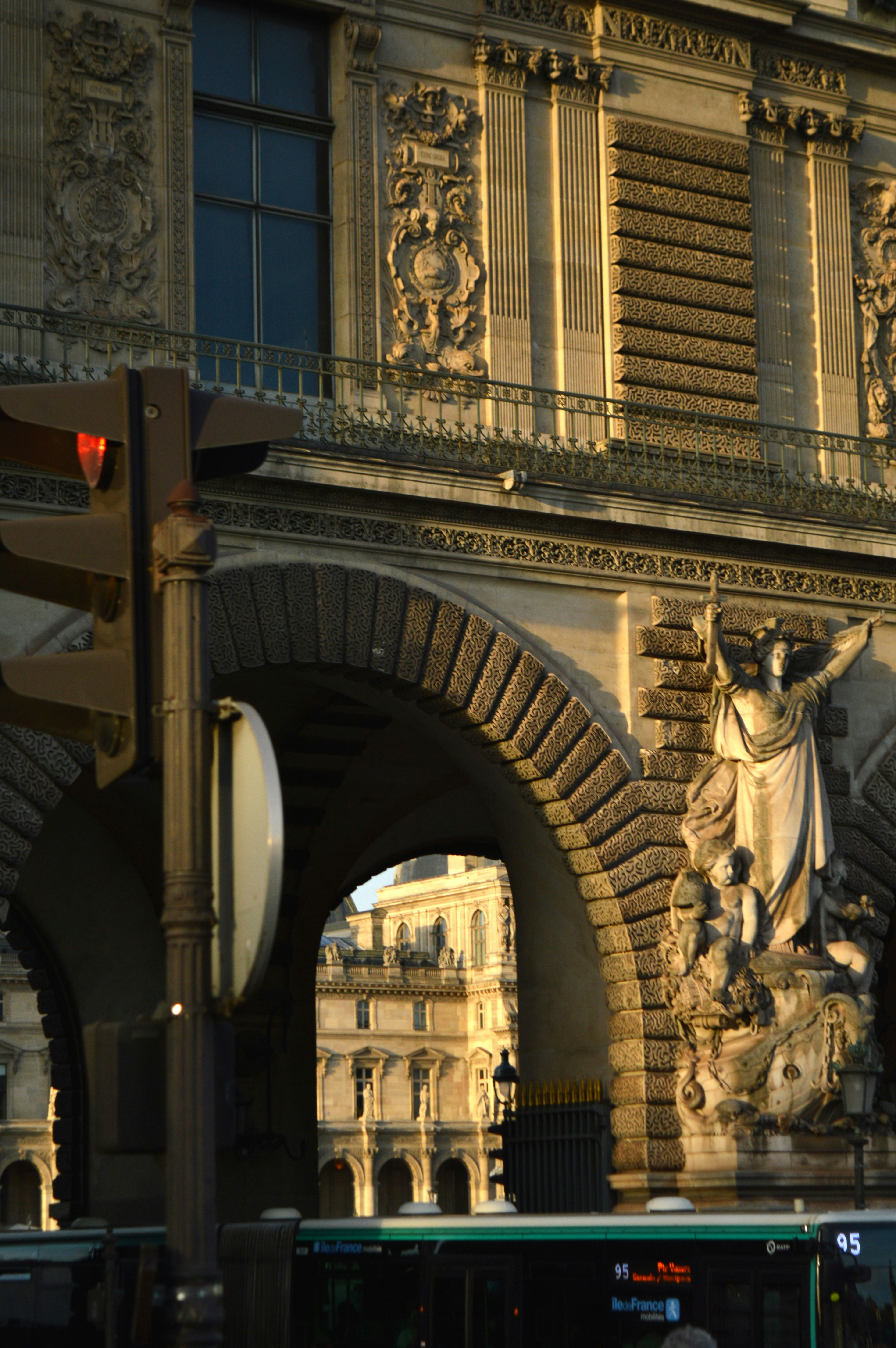 Un bus passe devant un grand bâtiment avec une statue sur le côté photo ...