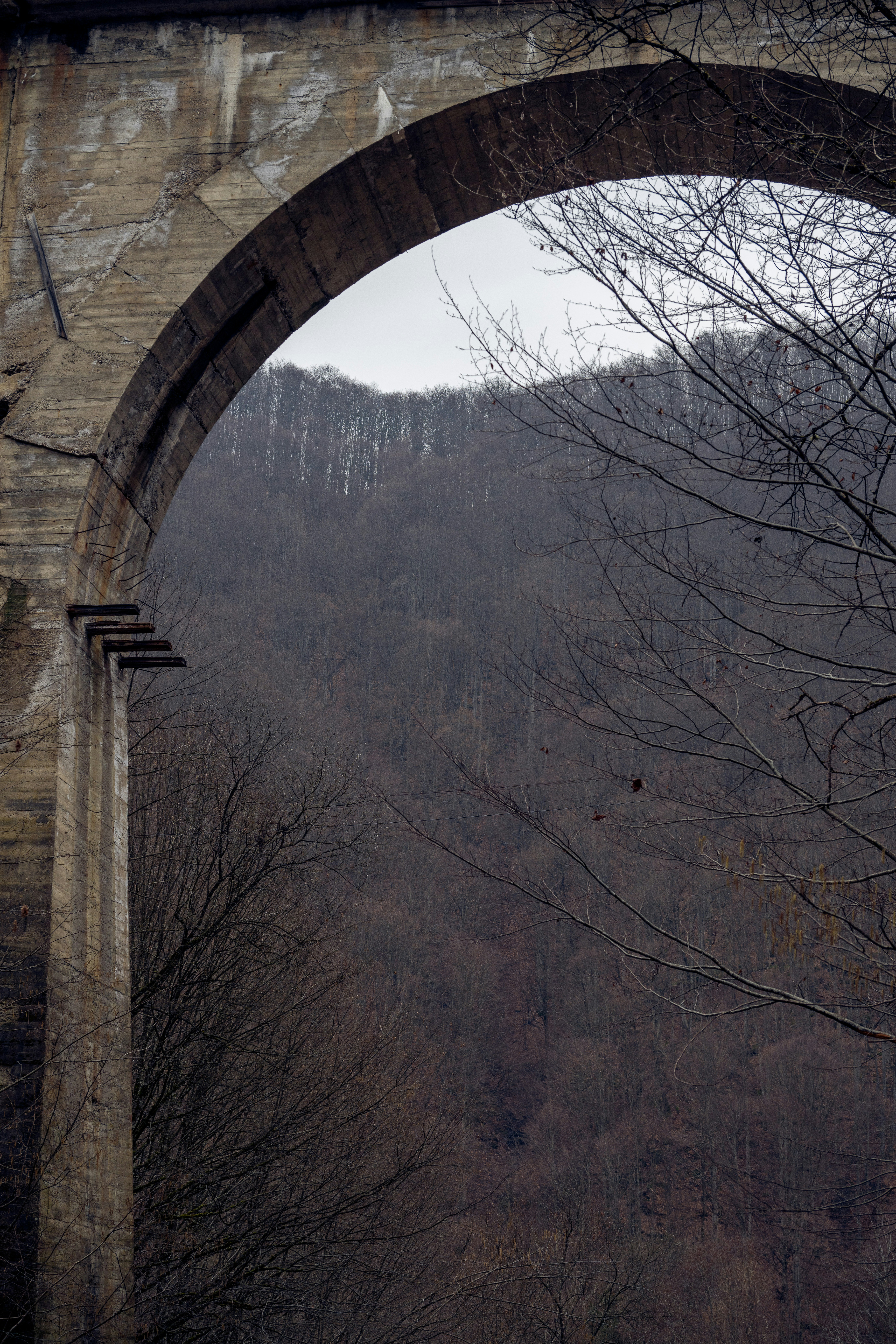 The Winter Arch: Stone Gate Framing a Quiet Valley