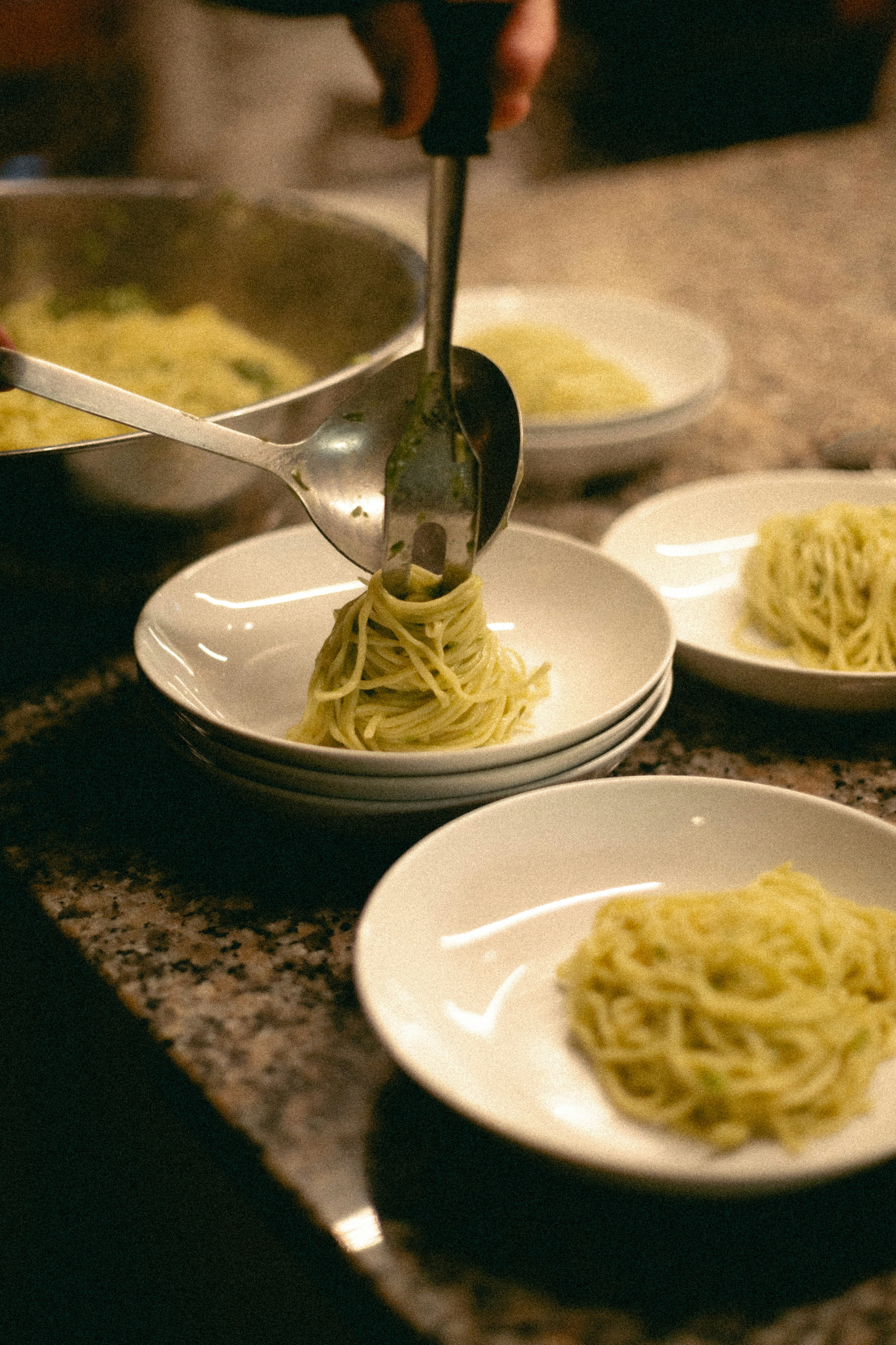 A person is spooning spaghetti into a bowl photo – Free Food Image on ...