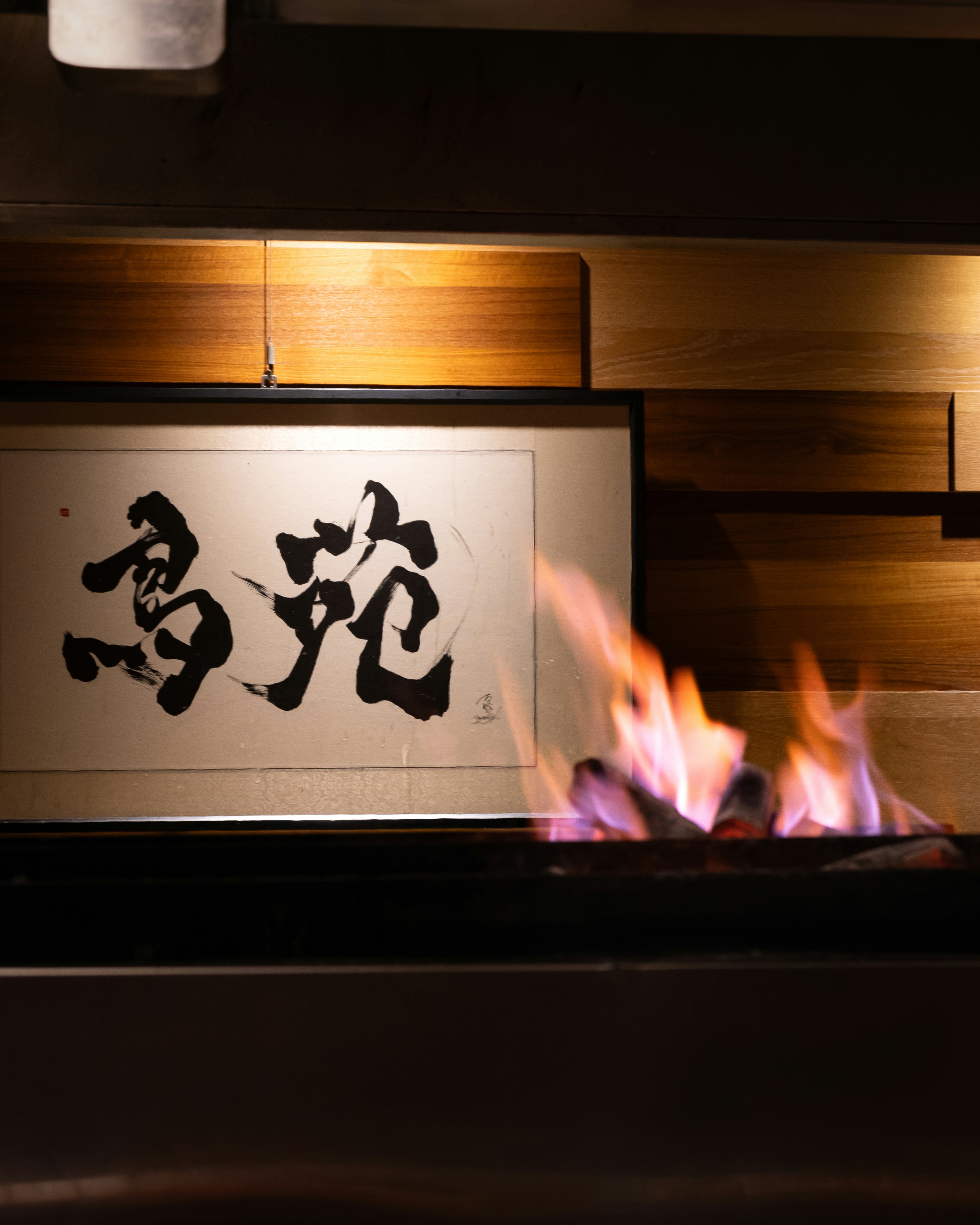 Calligraphic Fire: Inked Characters Framed by Warm Hearth Light