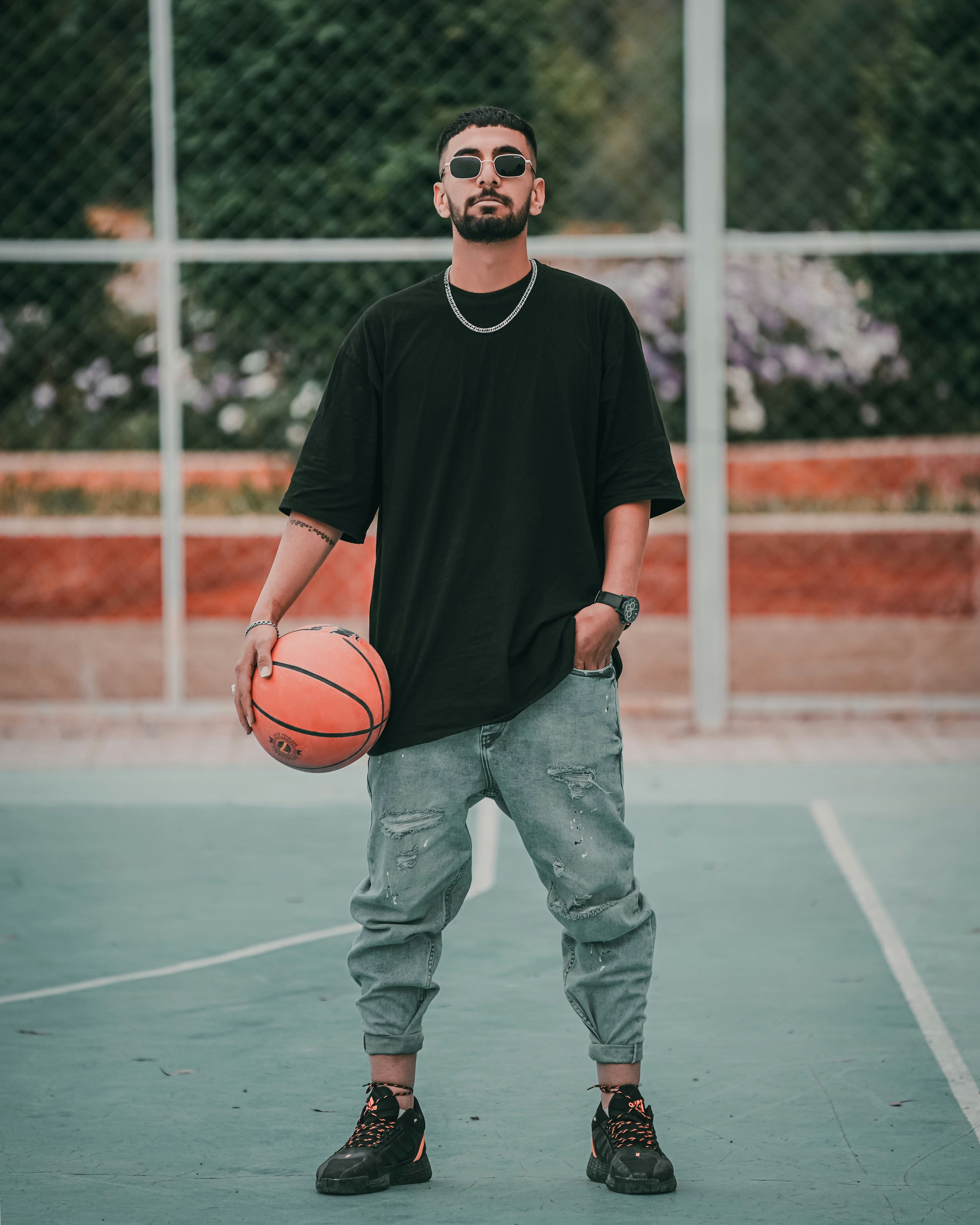Monochrome Moment on a Quiet Court: A poised player with basketball amid a pastel backdrop