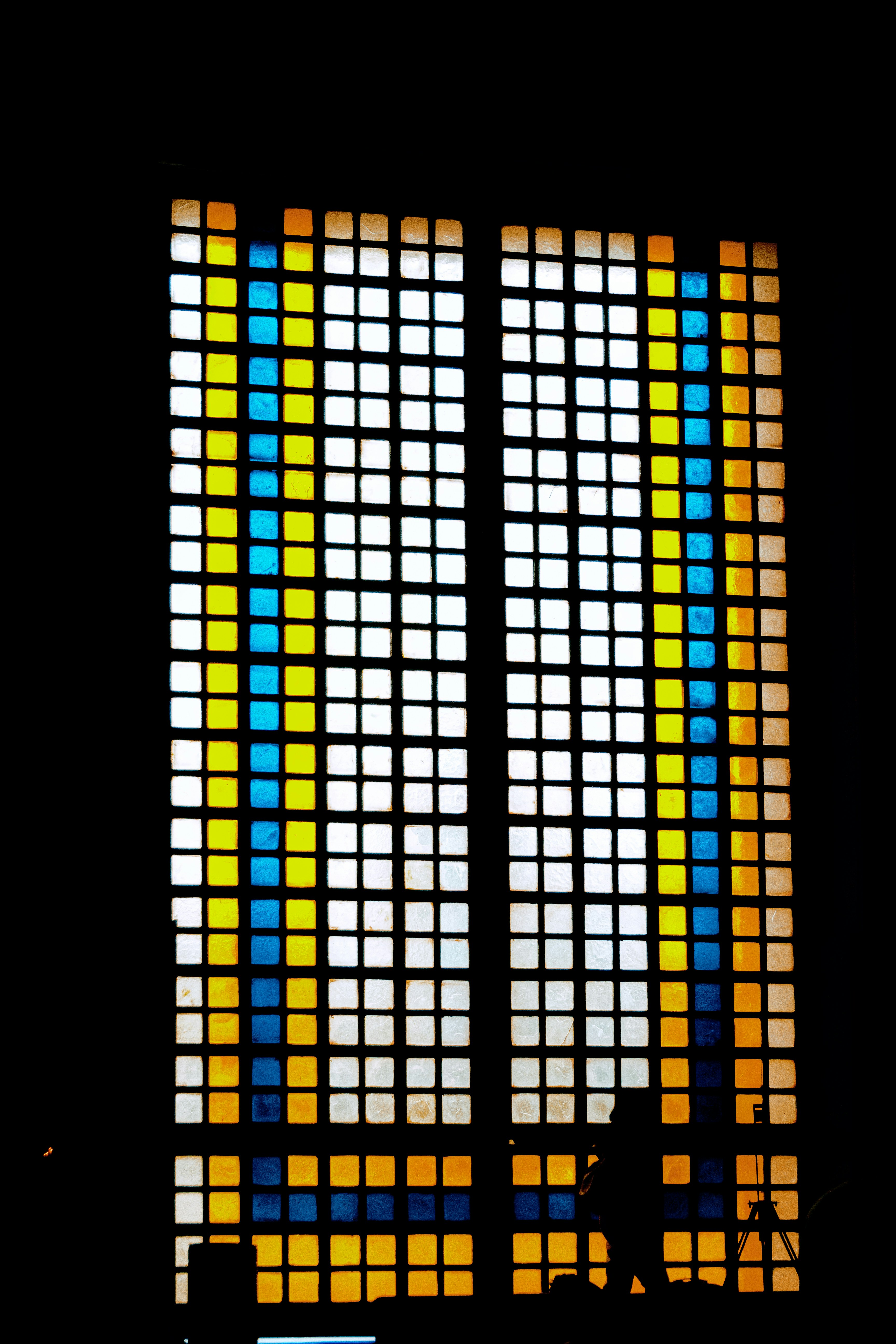 a person sitting in front of a stained glass window