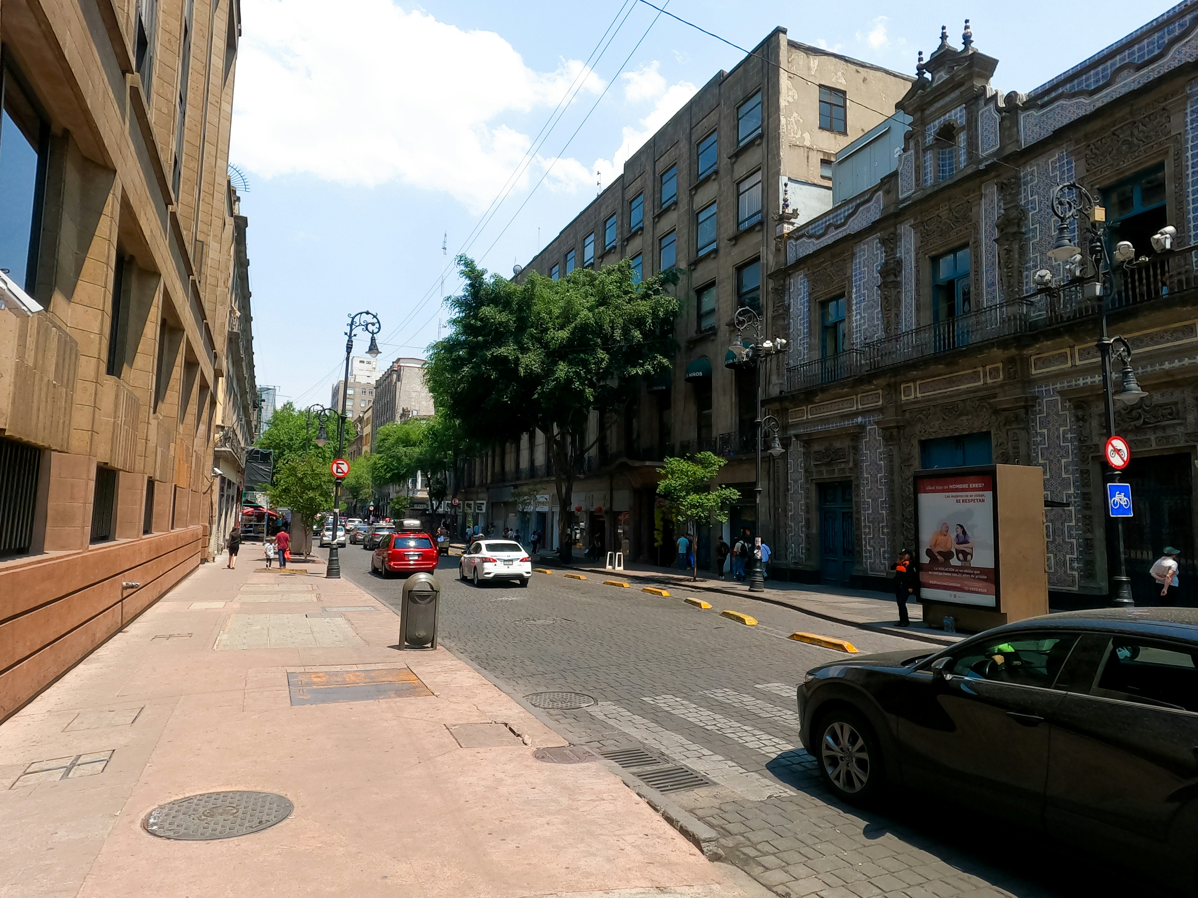A city street lined with tall buildings and parked cars photo – Free ...
