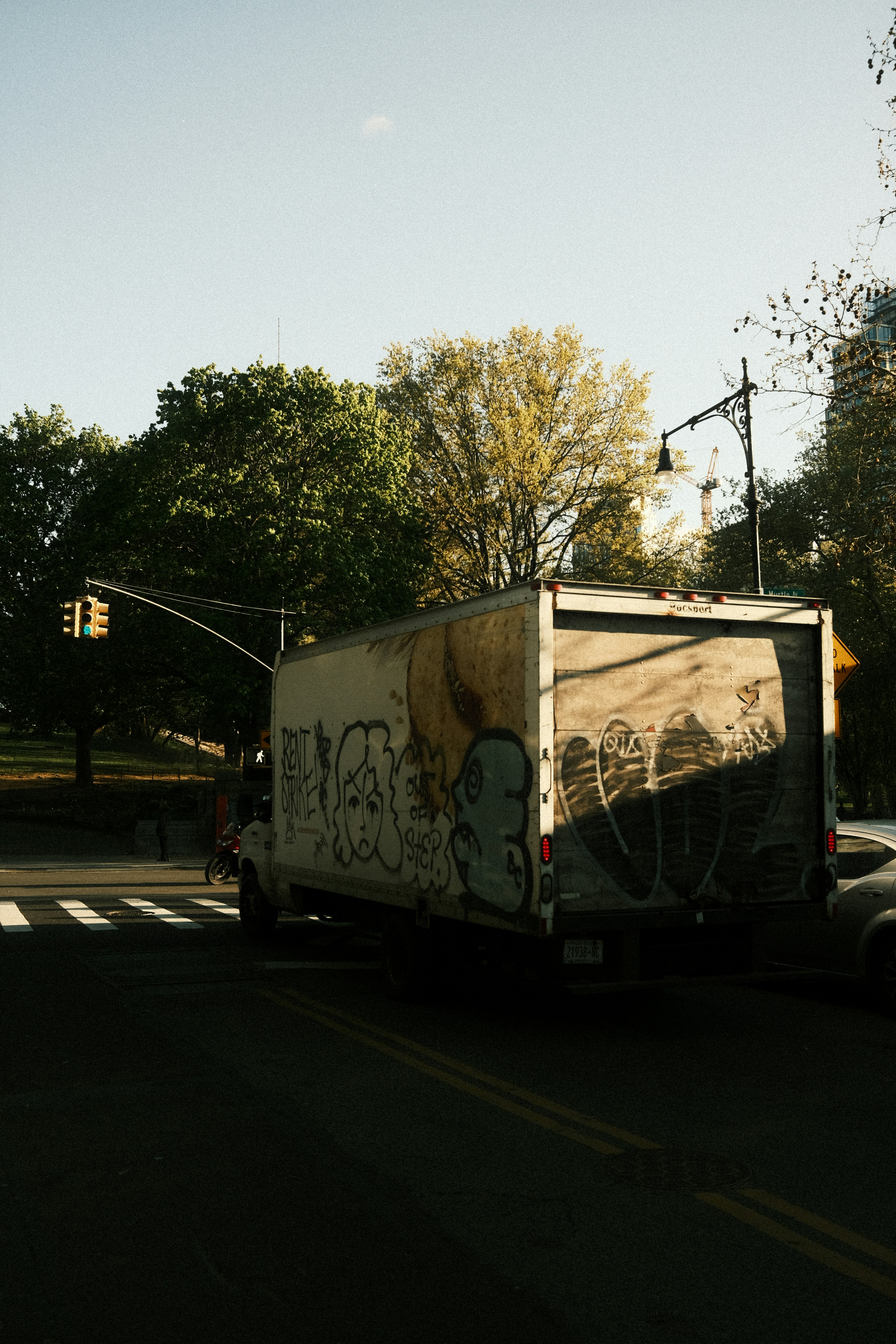 Graffiti-Dusted Delivery Truck Under Autumn Sun at a Quiet City Intersection