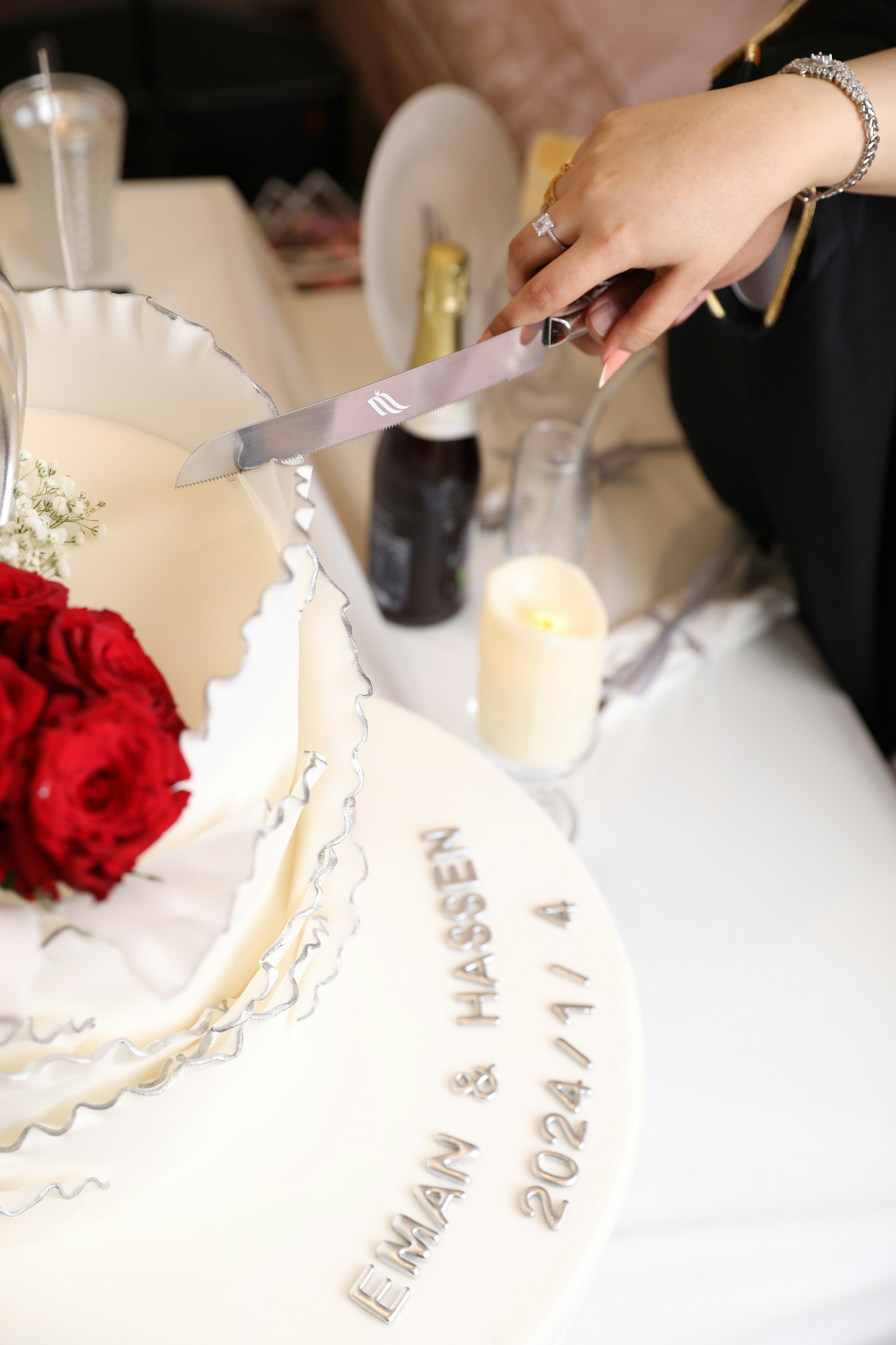 Bride’s Cut: A Knife poised above a tiered wedding cake with red roses and celebratory details