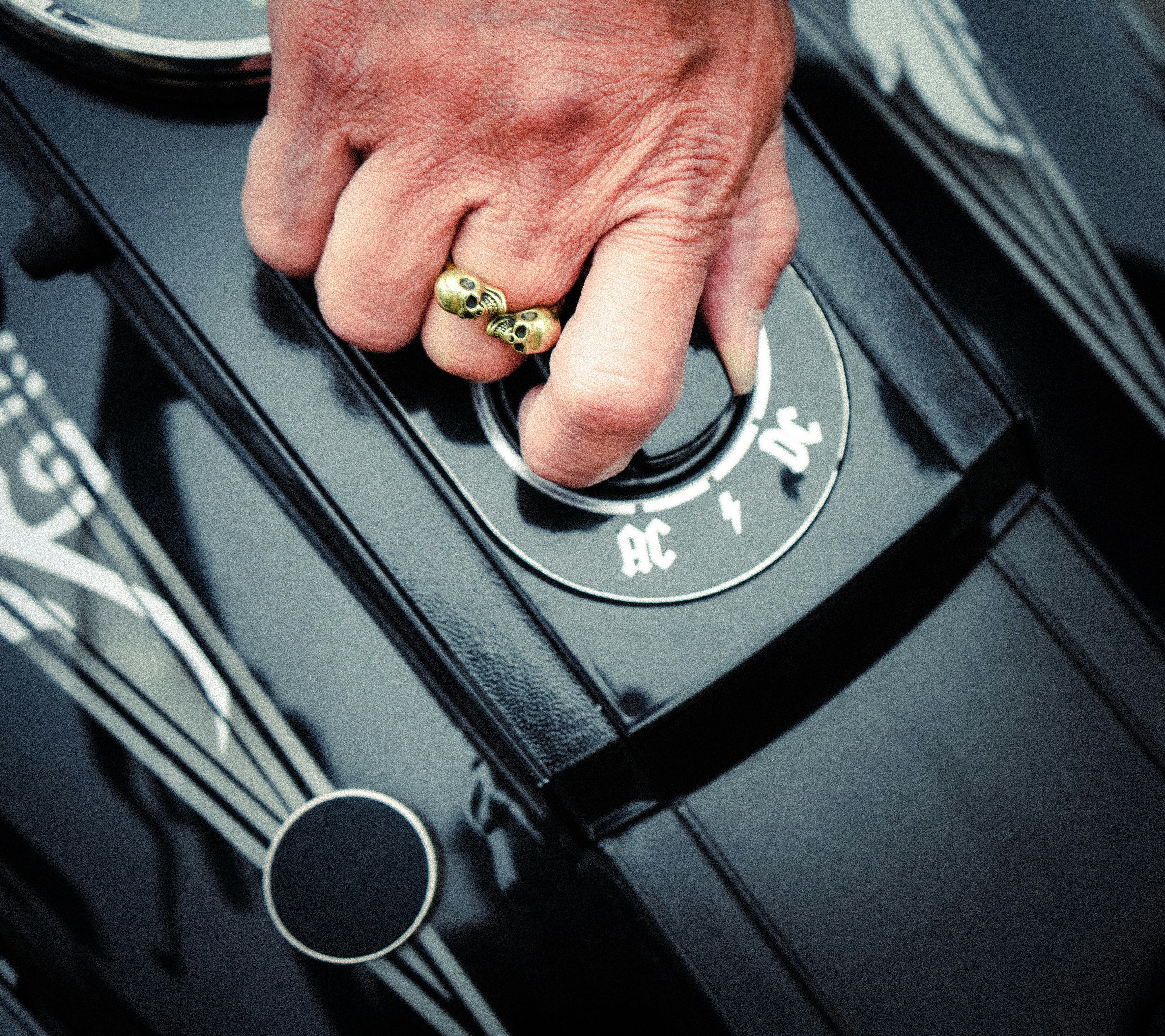 Rings on Chrome: A close-up of a biker's hand gripping a glossy motorcycle dial