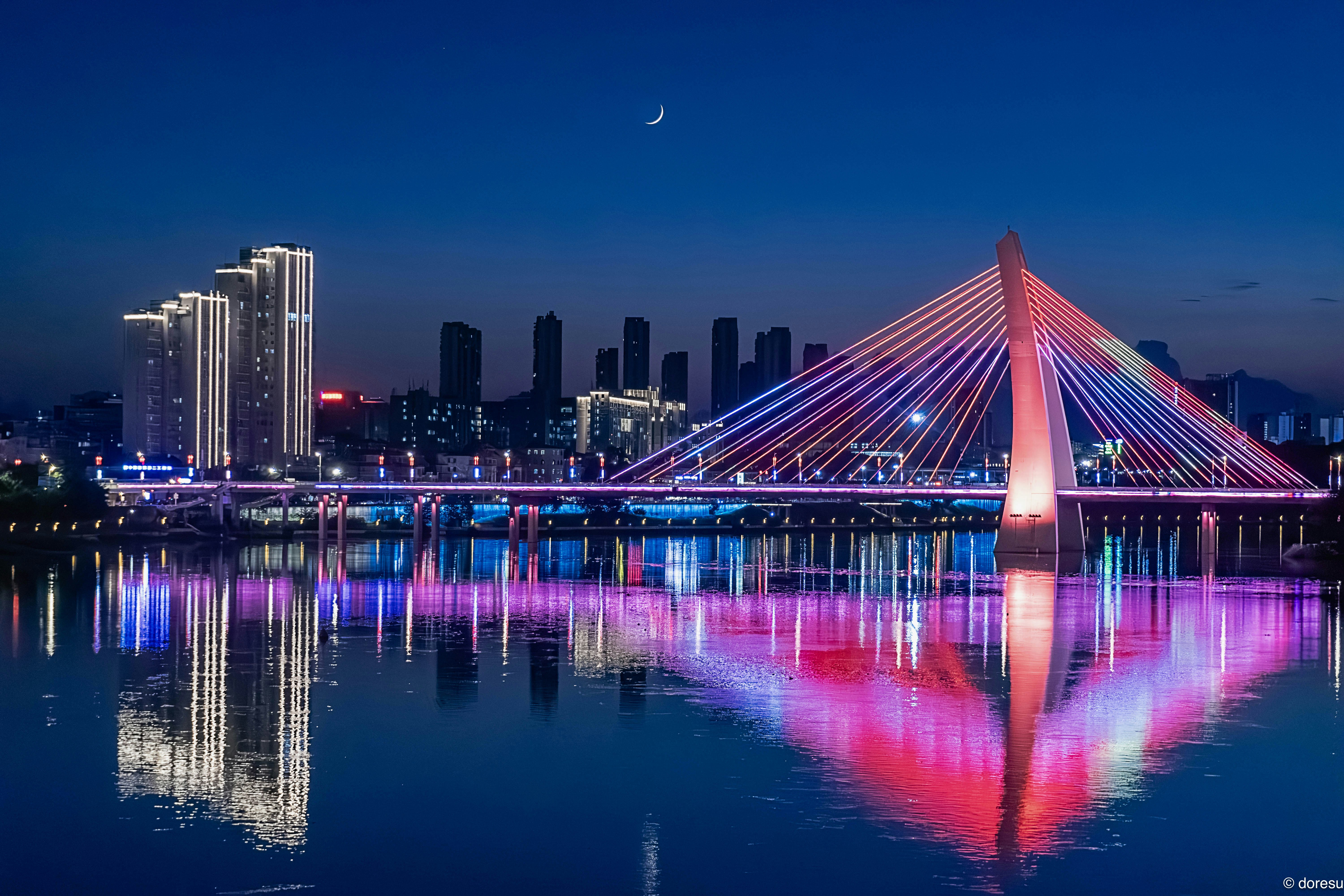 outdoor lighting | a large bridge over a body of water with a city in the background