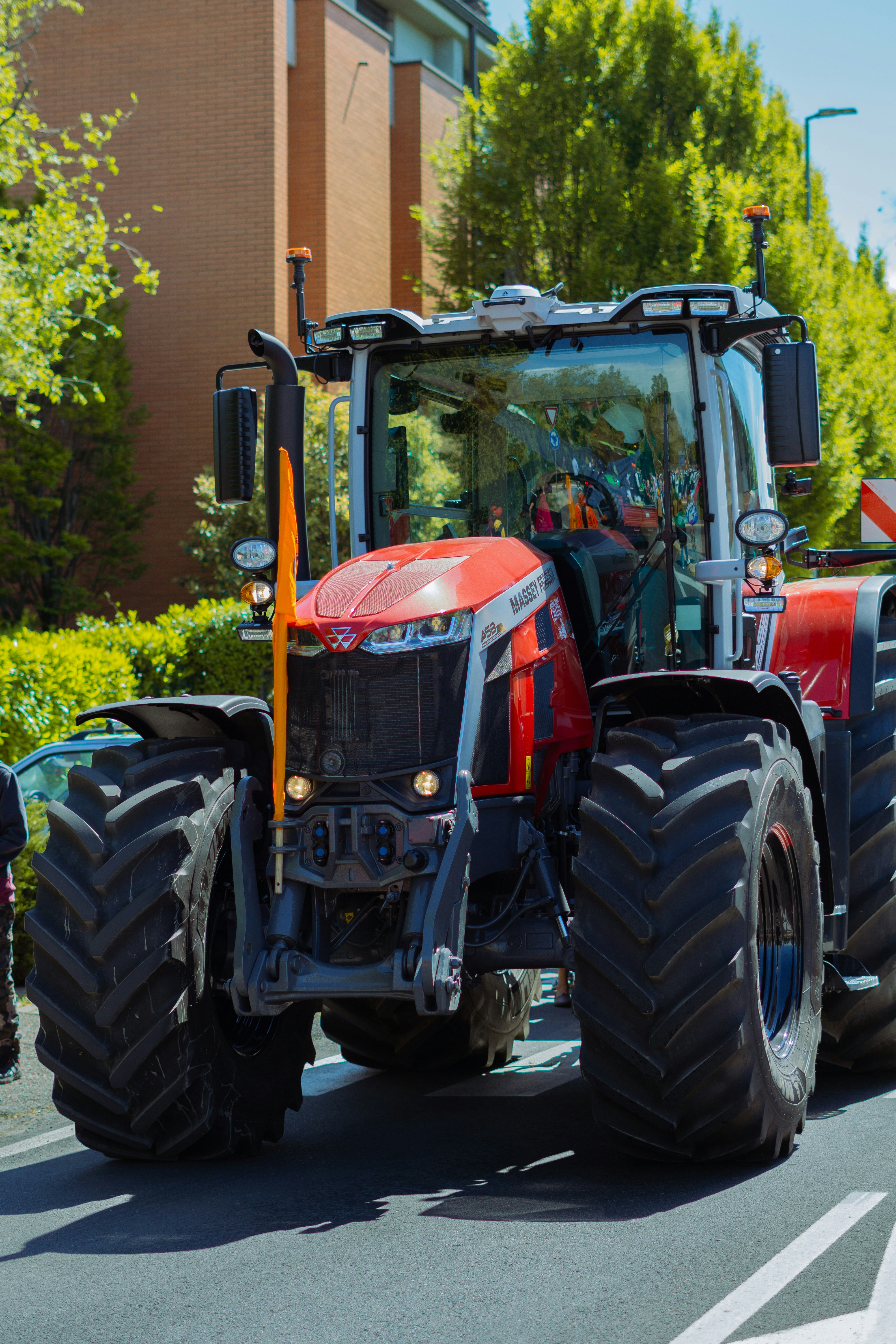 Urban Giant: Red Massey Ferguson Tractor Rounds the City Block