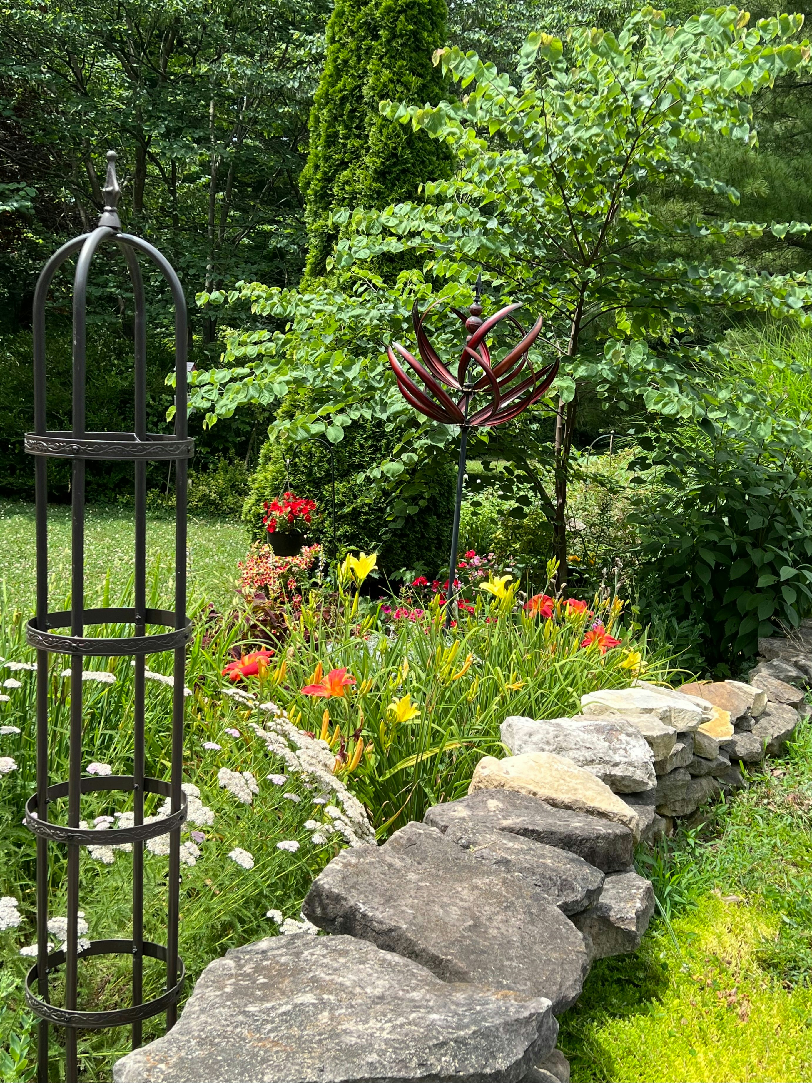 Crimson Metal Bloom Rising Over a Stone-Edged Garden