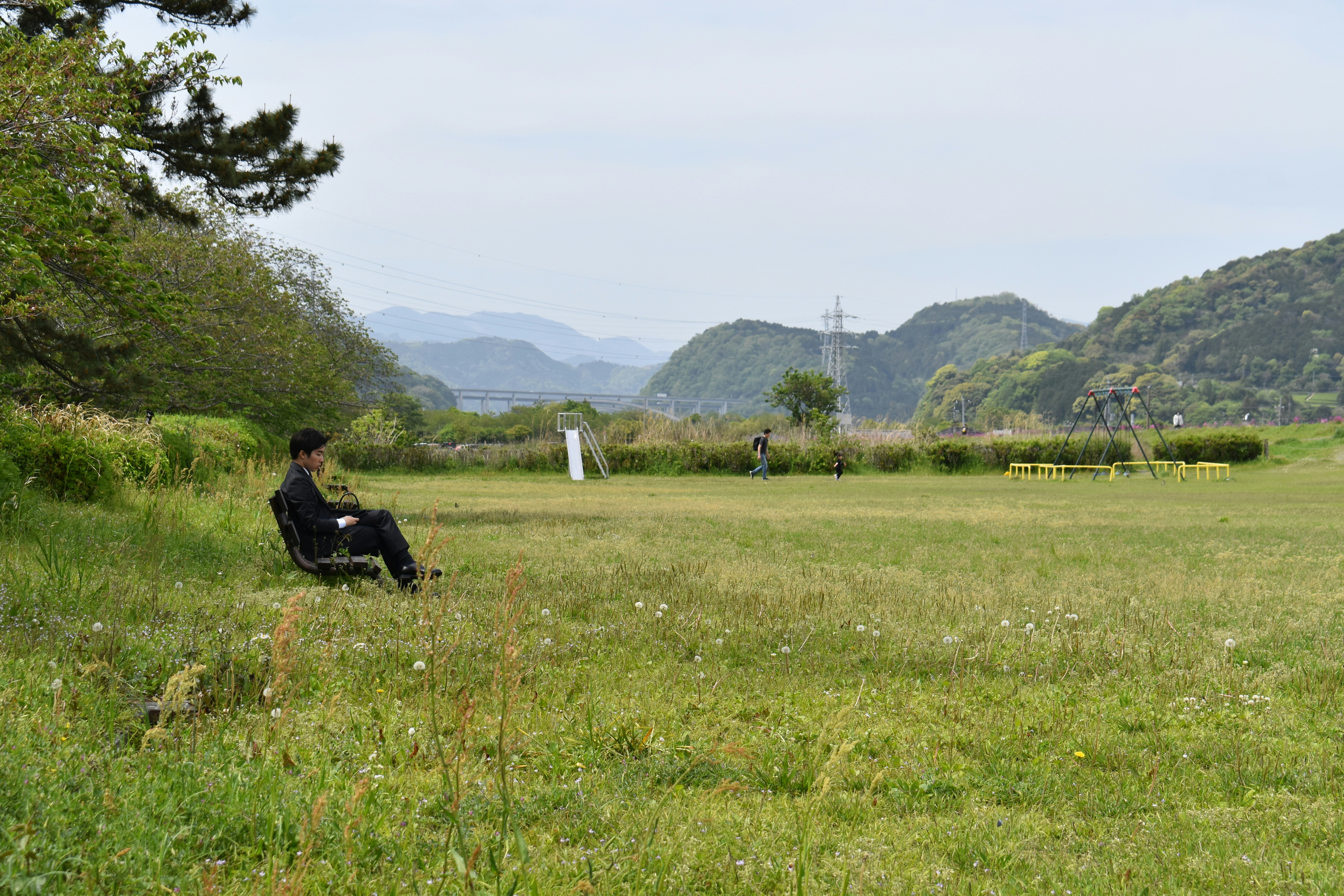Man in suit sitting in the park afterwork in front of Fuji Mount