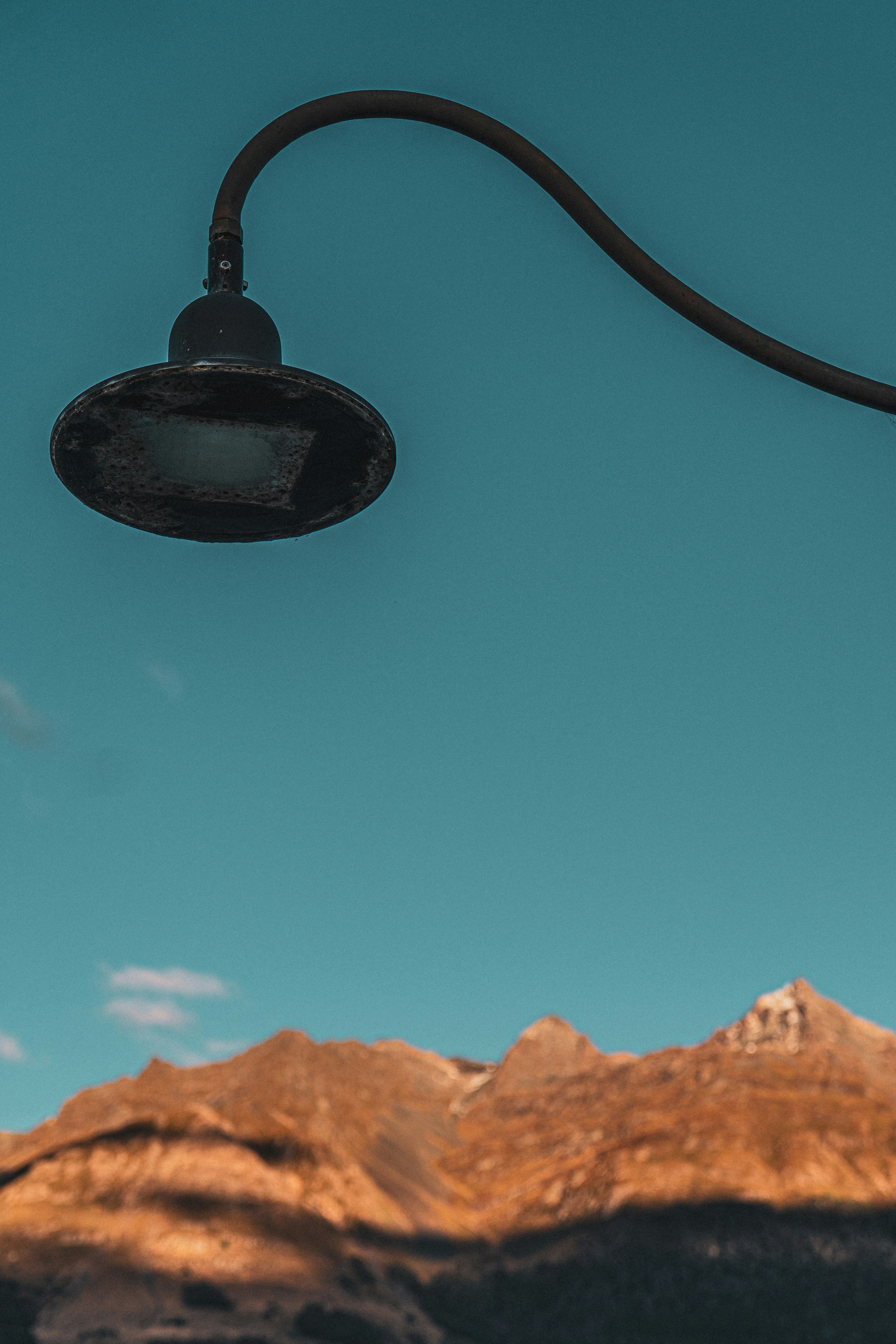 Curved Cable, Lone Lamp, and a Turquoise Sky over Mountain Ridge