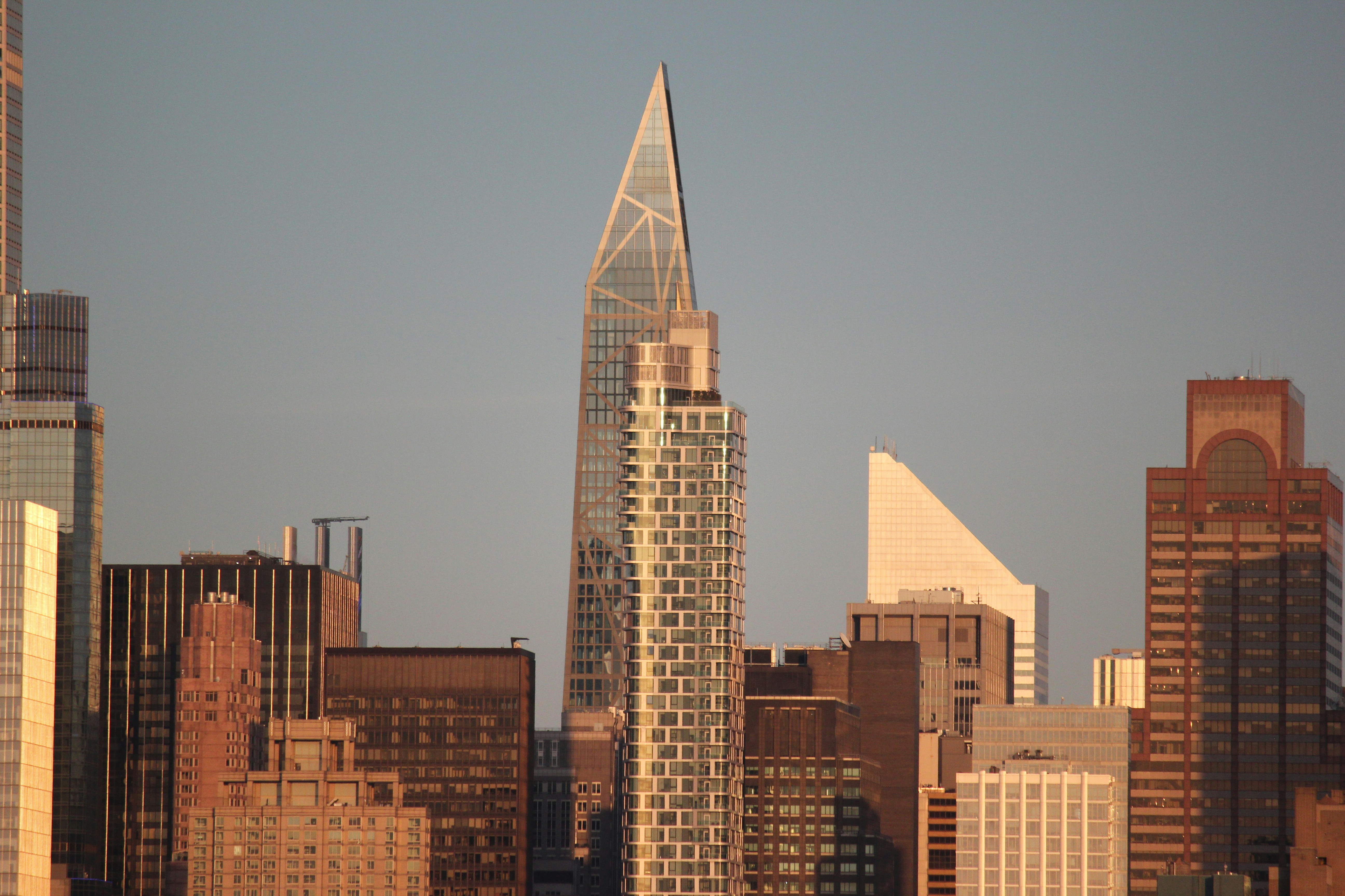 A very tall building towering over a city photo – Free City Image on ...
