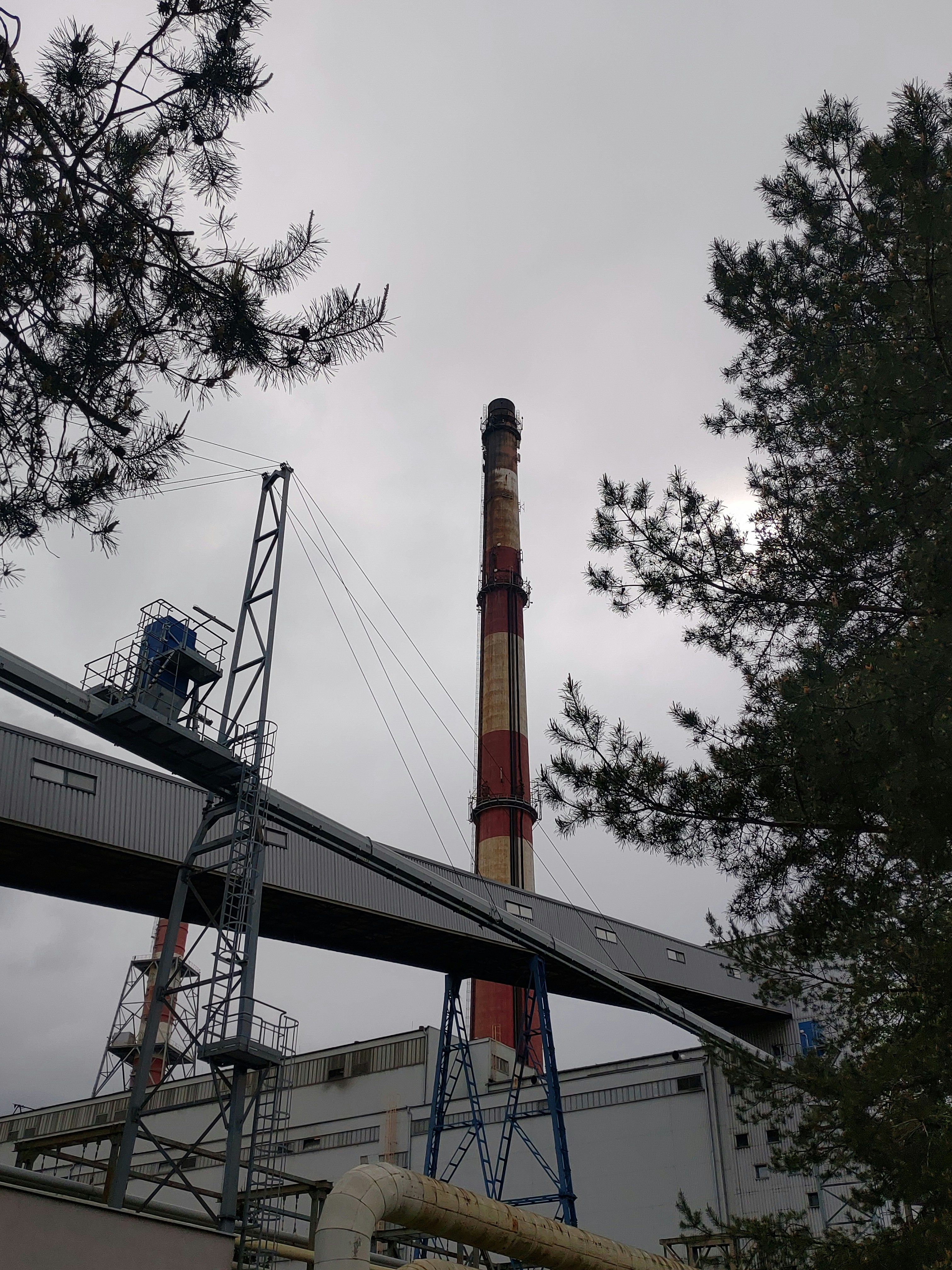 Towering Industrial Chimney Rises Over Factory Complex