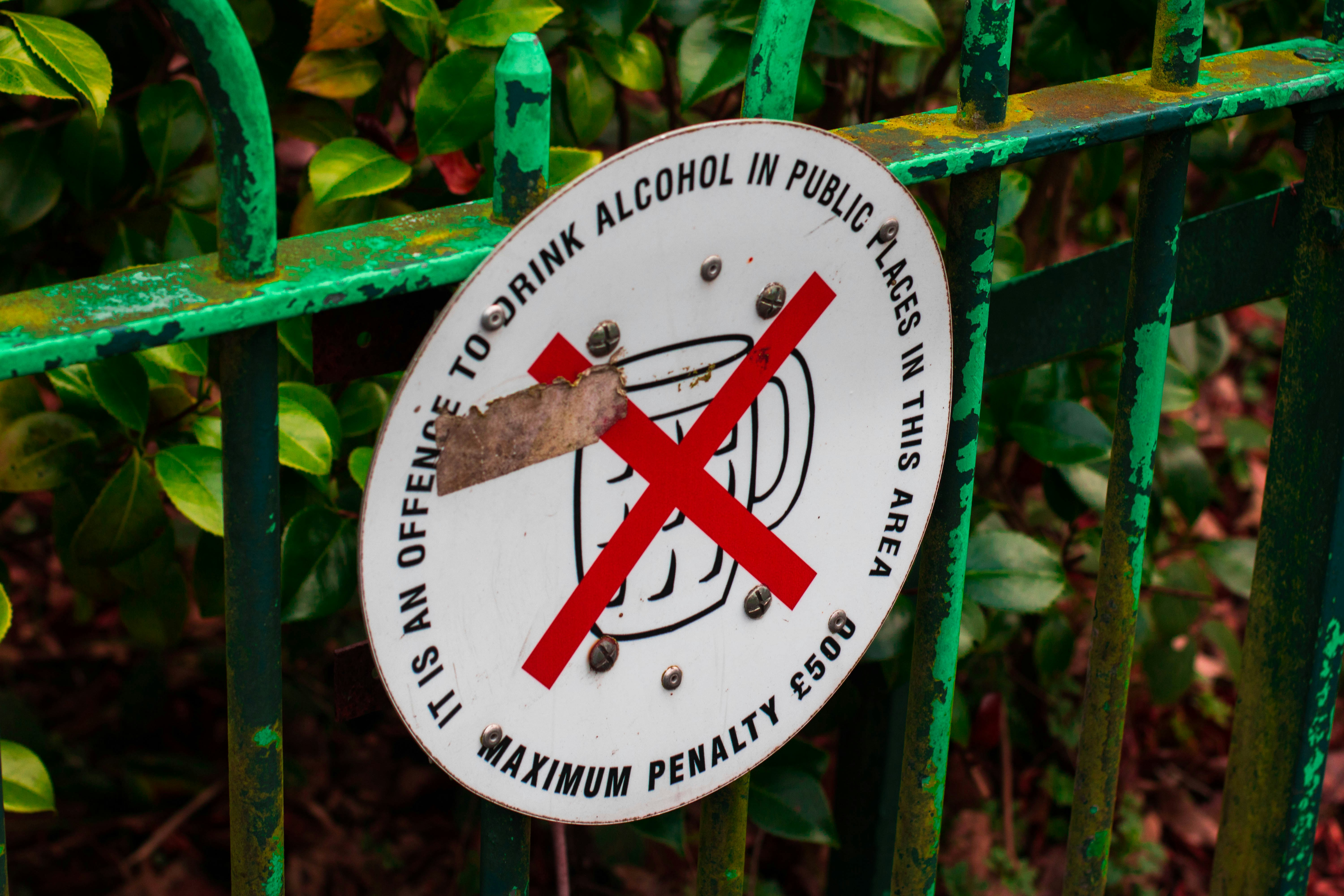 A sign on a fence that says no drinking alcohol in public photo – Free ...