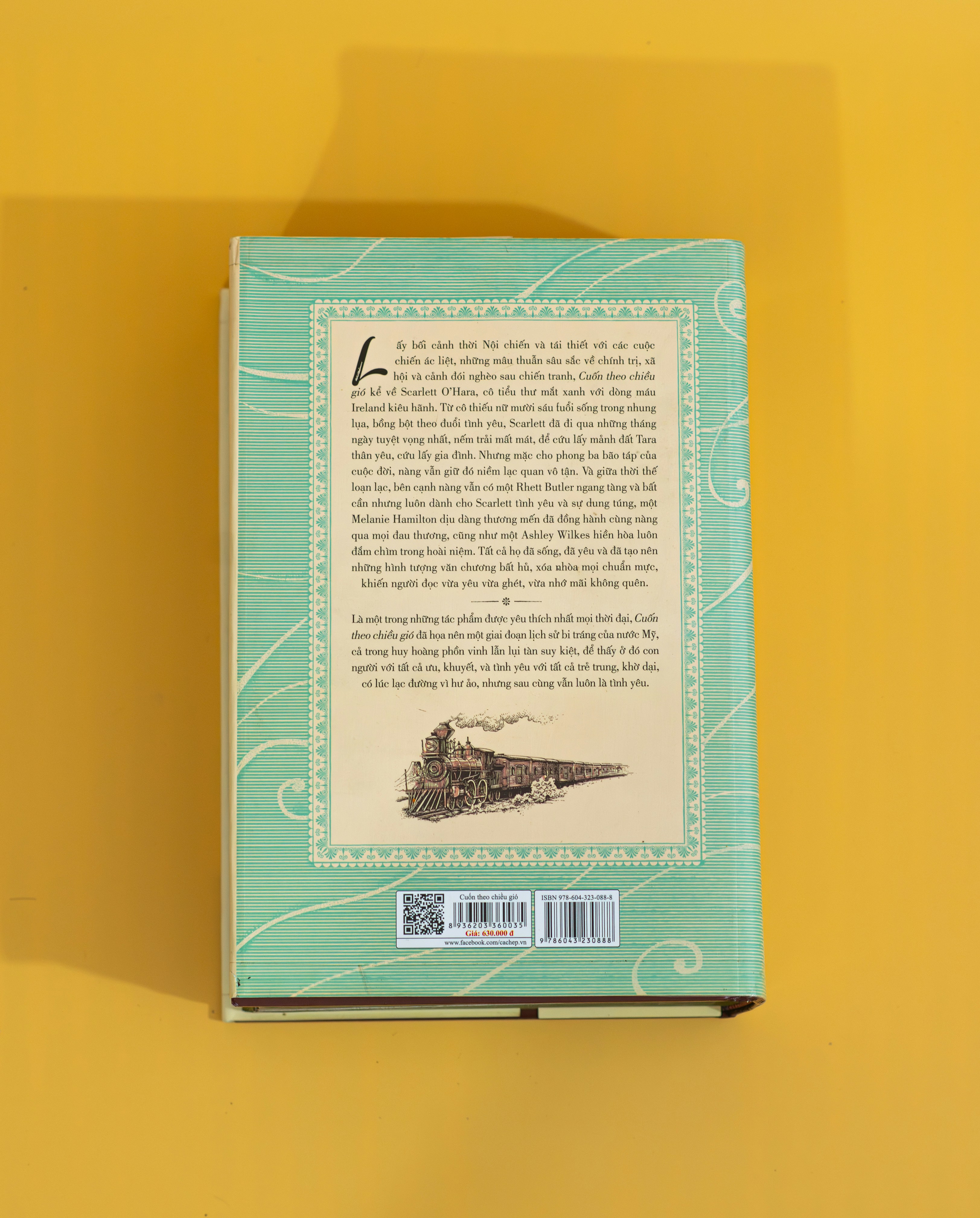 Teal Packaging with a Vintage Train Emblem on a Sunlit Yellow Surface