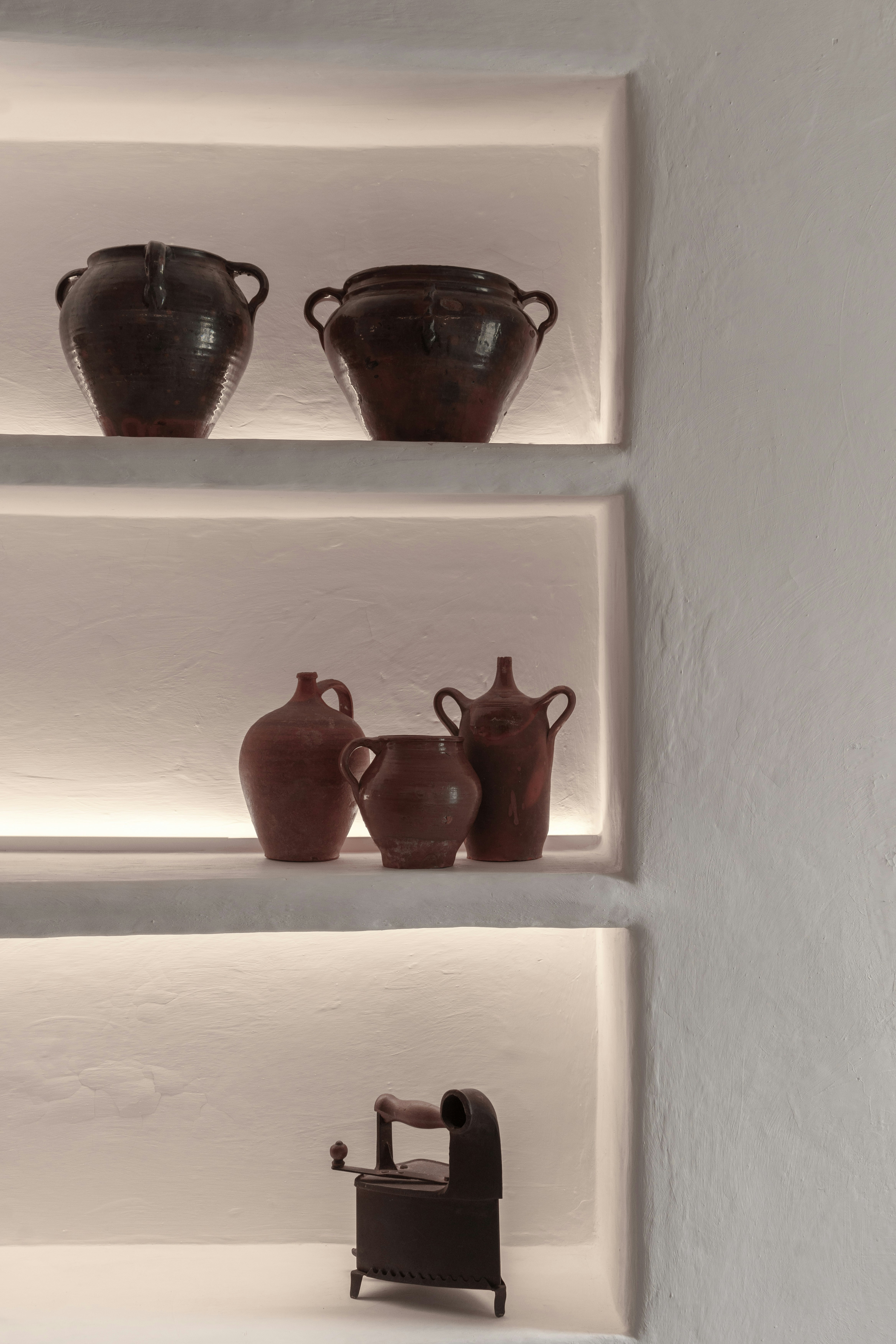 Terracotta Trio: Quiet Geometry on Backlit Shelves
