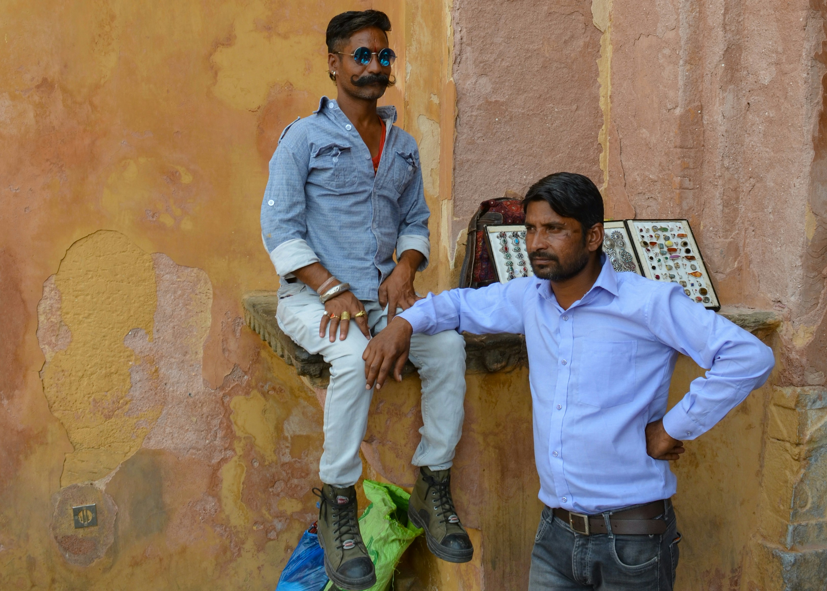 Two men sitting on a bench in front of a building photo – Free Portrait ...