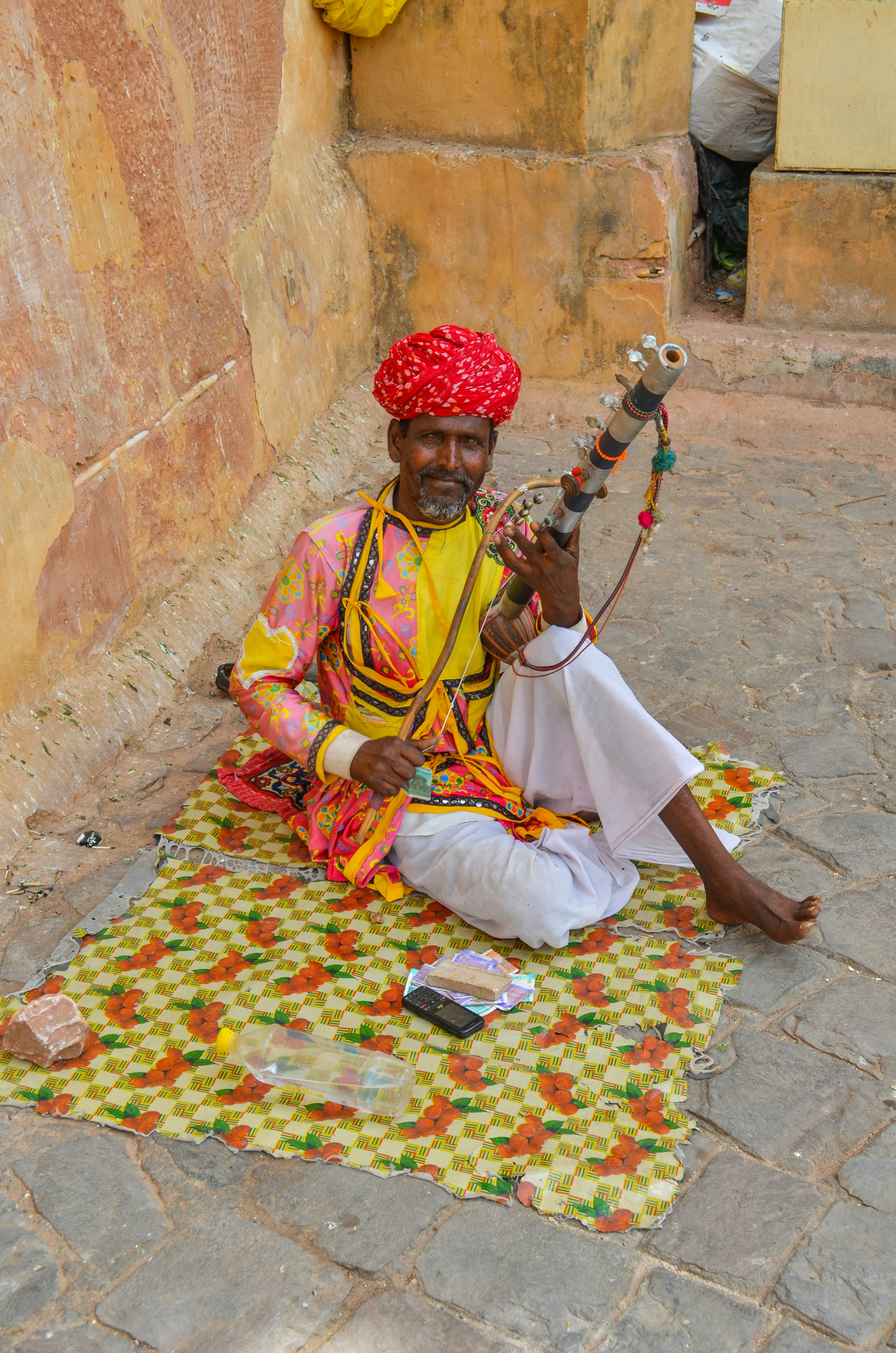 A man sitting on the ground playing a musical instrument photo – Free ...
