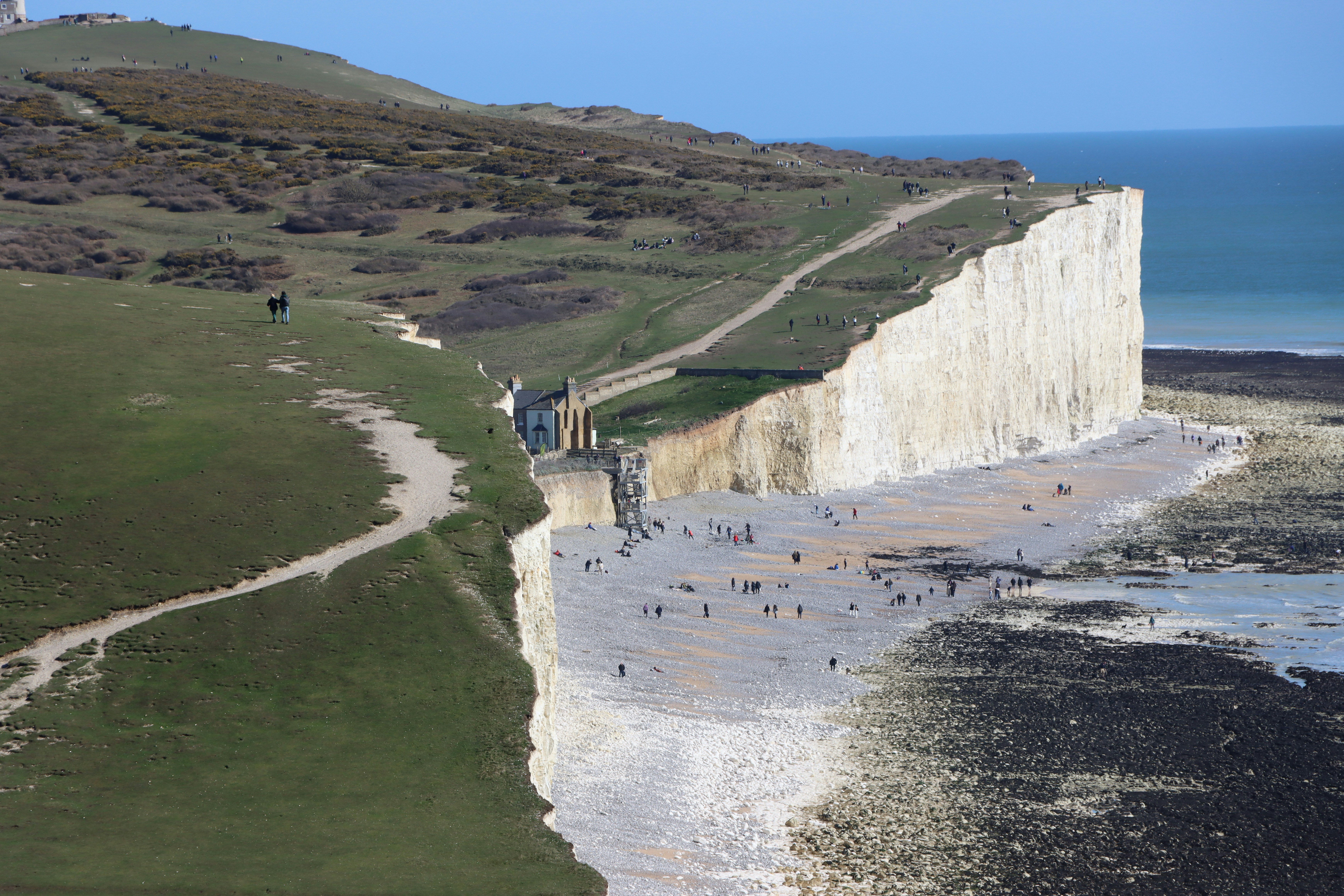 A group of people standing on the edge of a cliff photo – Free ...