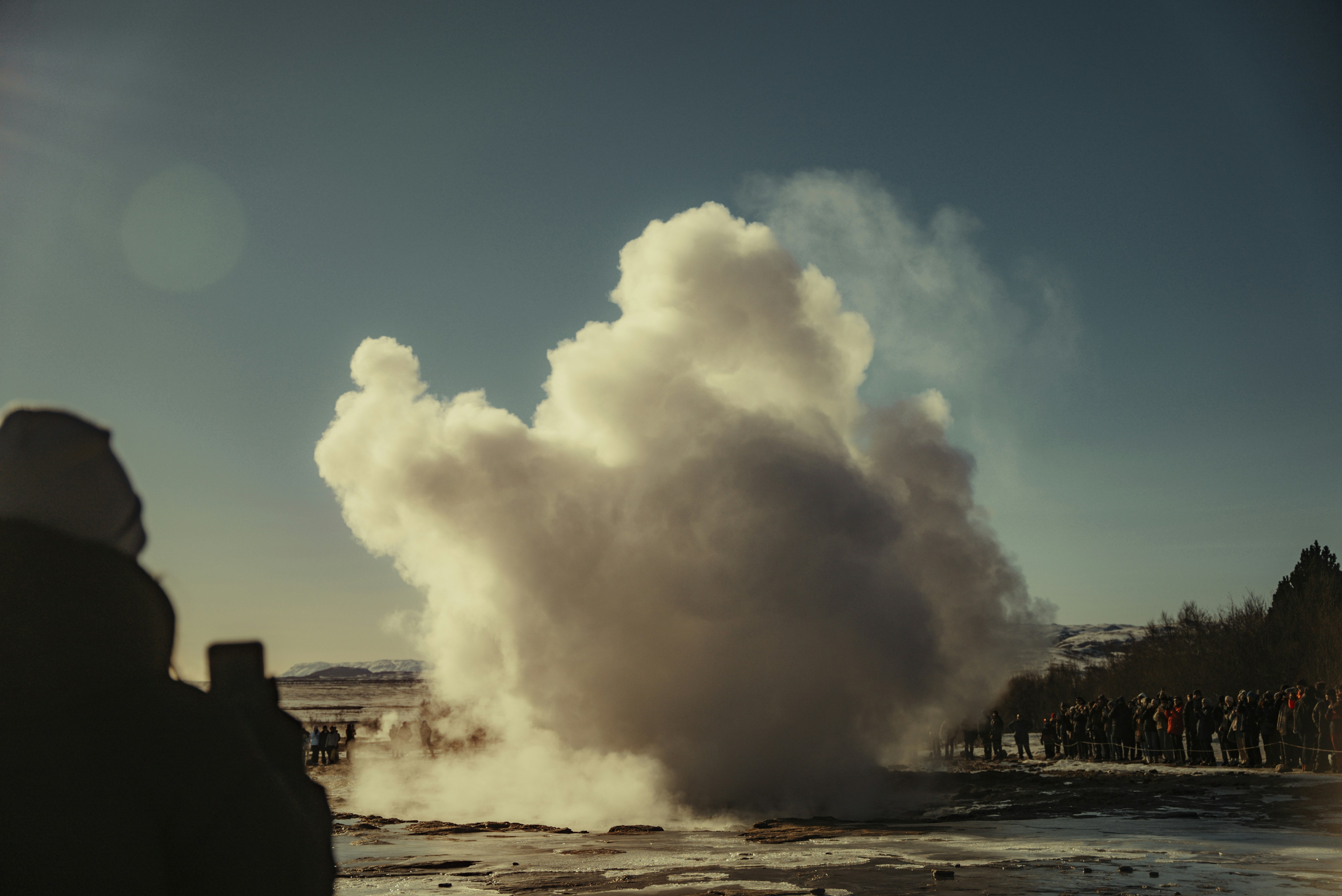 A group of people watching a large cloud of smoke photo – Free Man ...