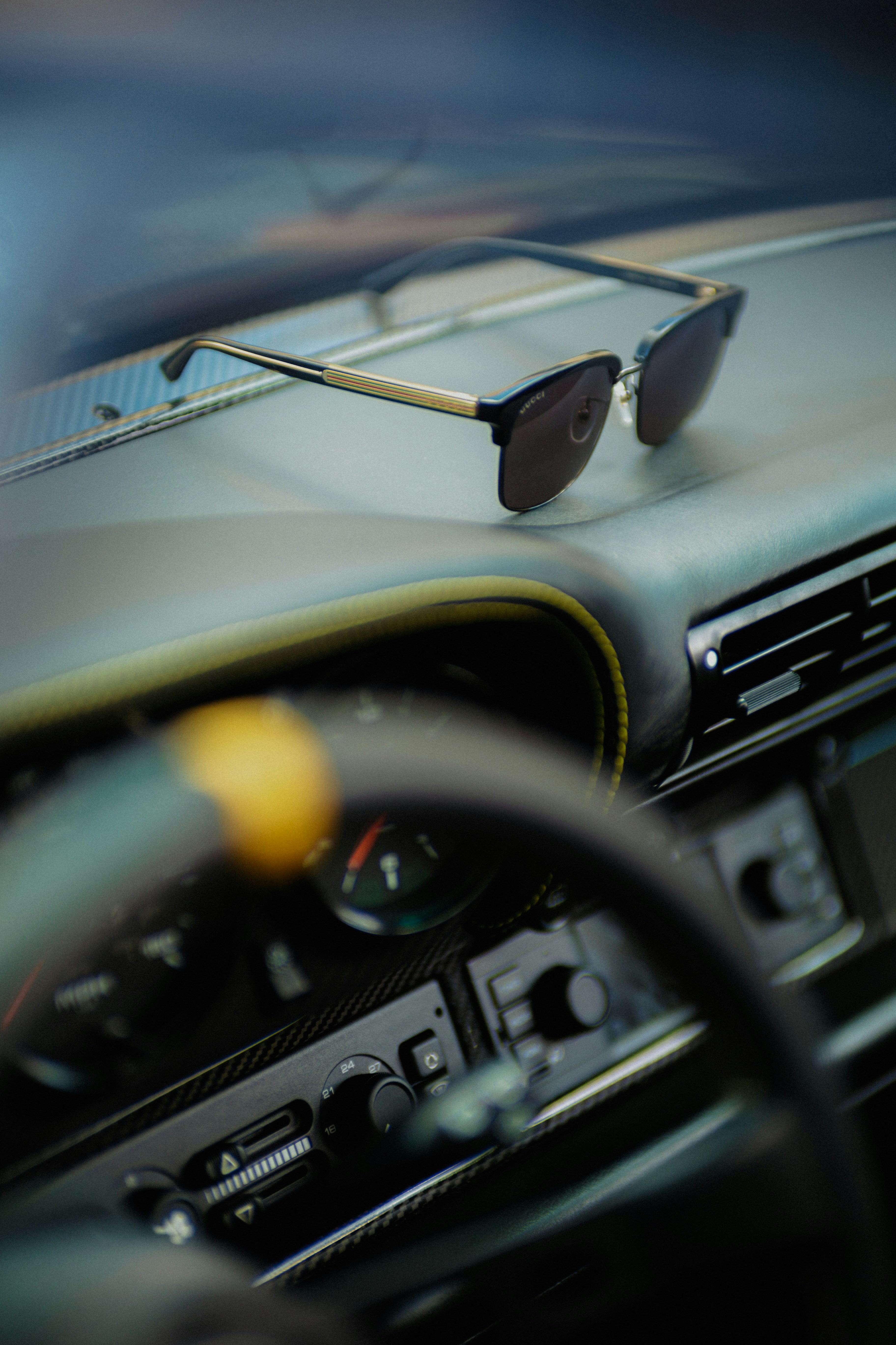 A car dashboard with a steering wheel and a pair of sunglasses photo ...