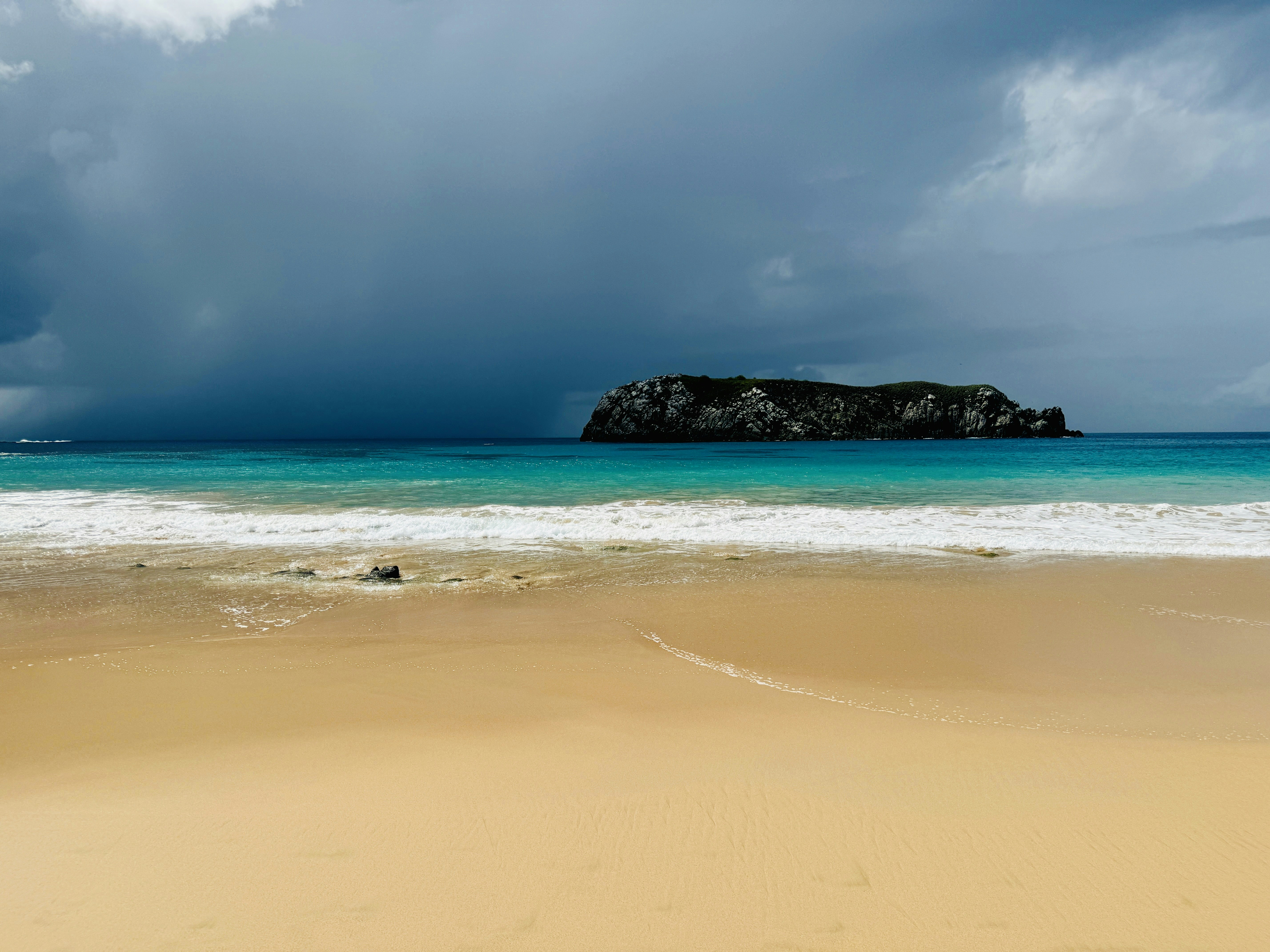 Islet at the Horizon Beneath a Looming Storm