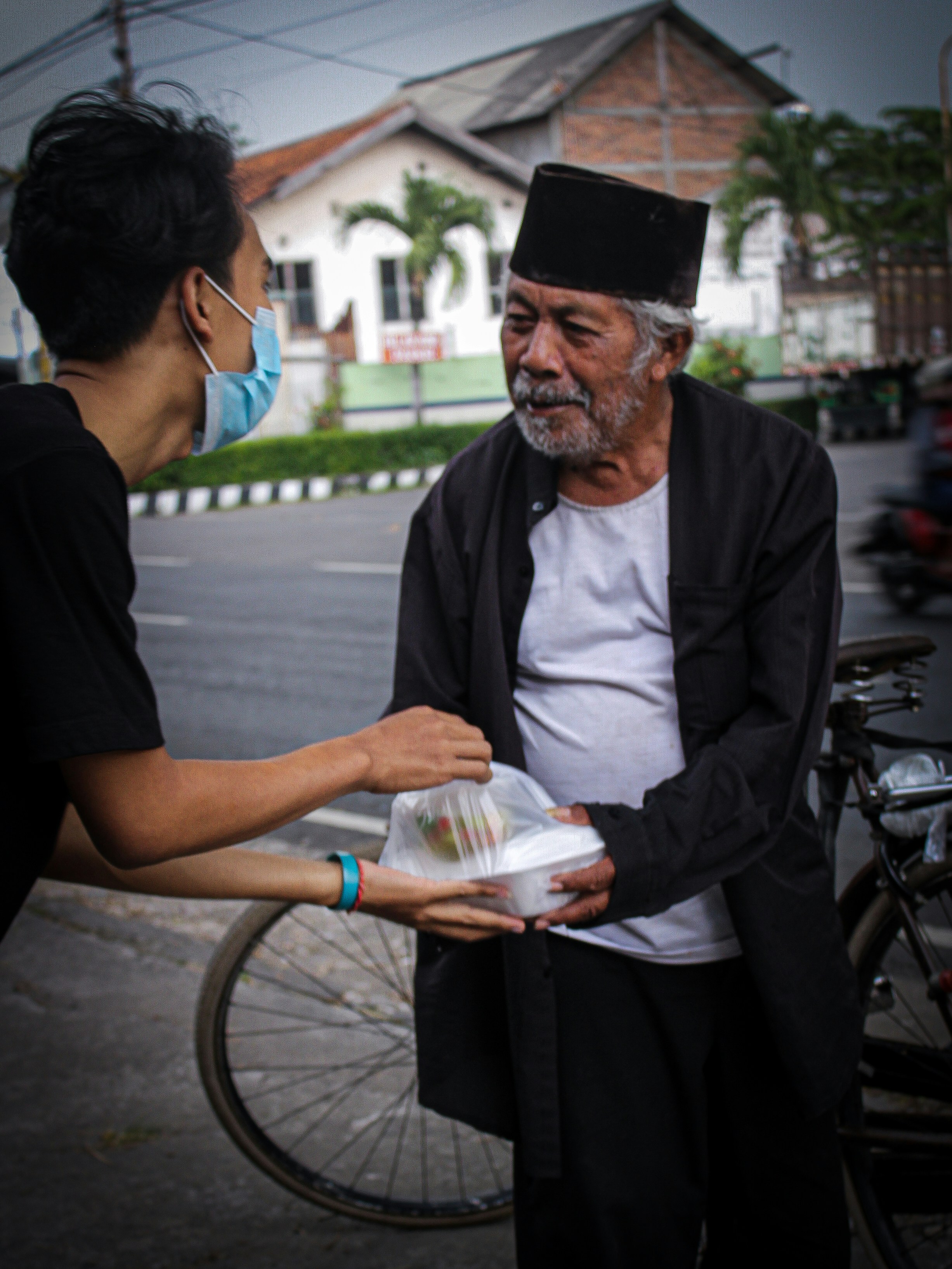 A man handing something to a woman on the street photo – Free Human ...