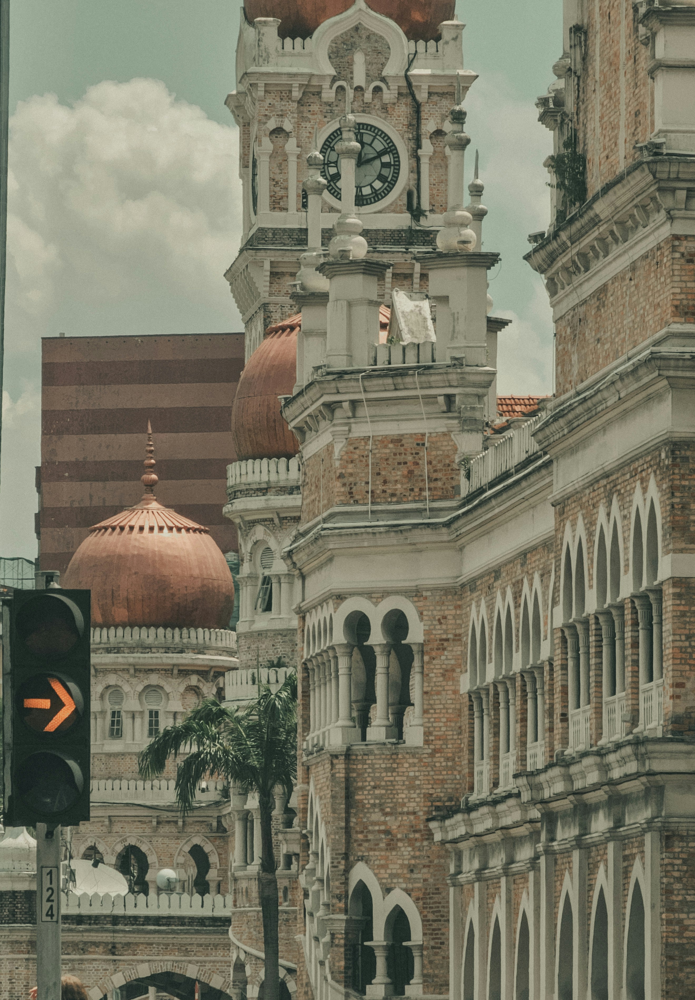 Clock-Tower Serenade: Brick Arches Meet Red Domes in a Sunlit City Street