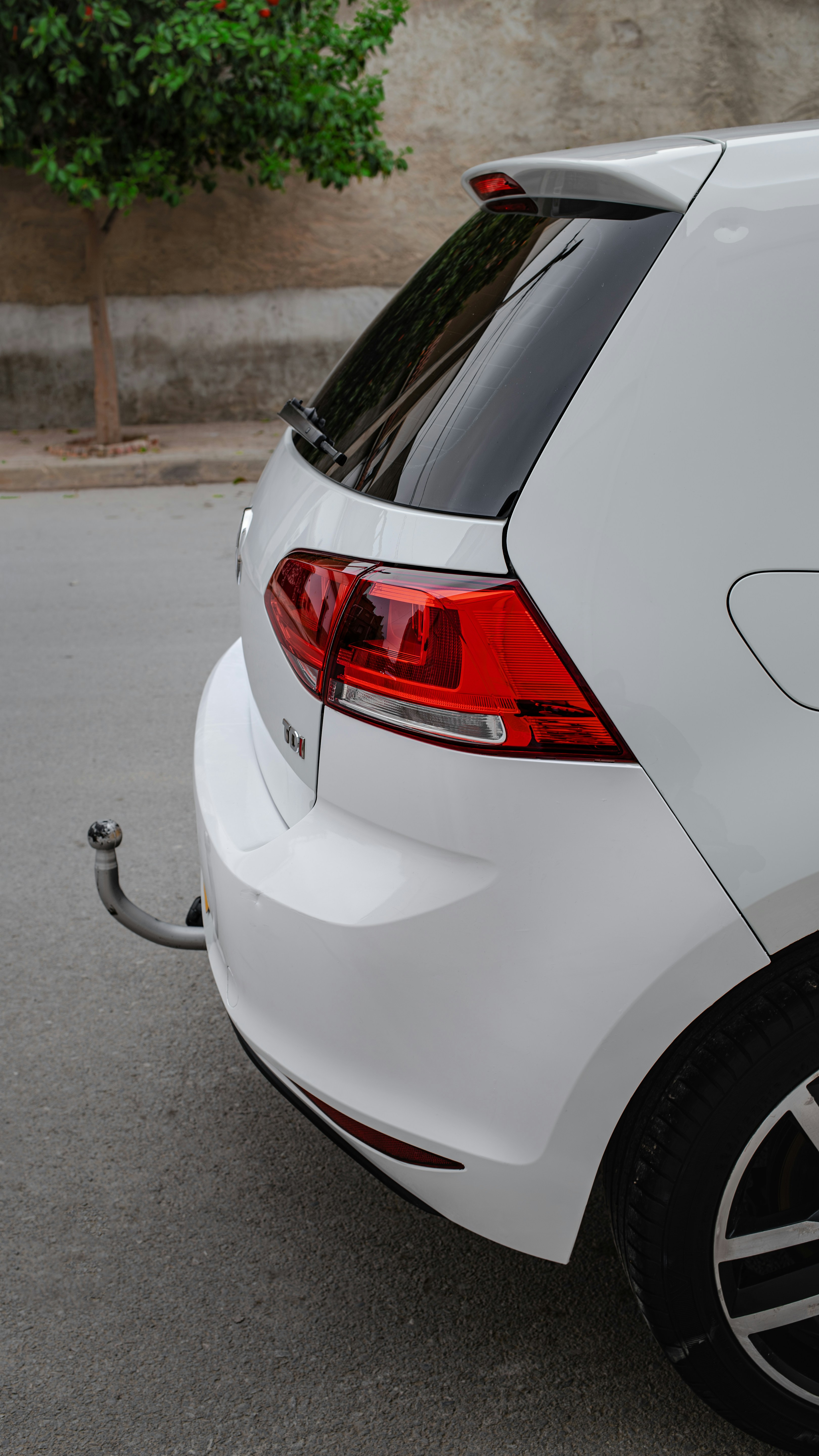 Rear Quarter Portrait: White Hatchback with Red Taillights on an Urban Street