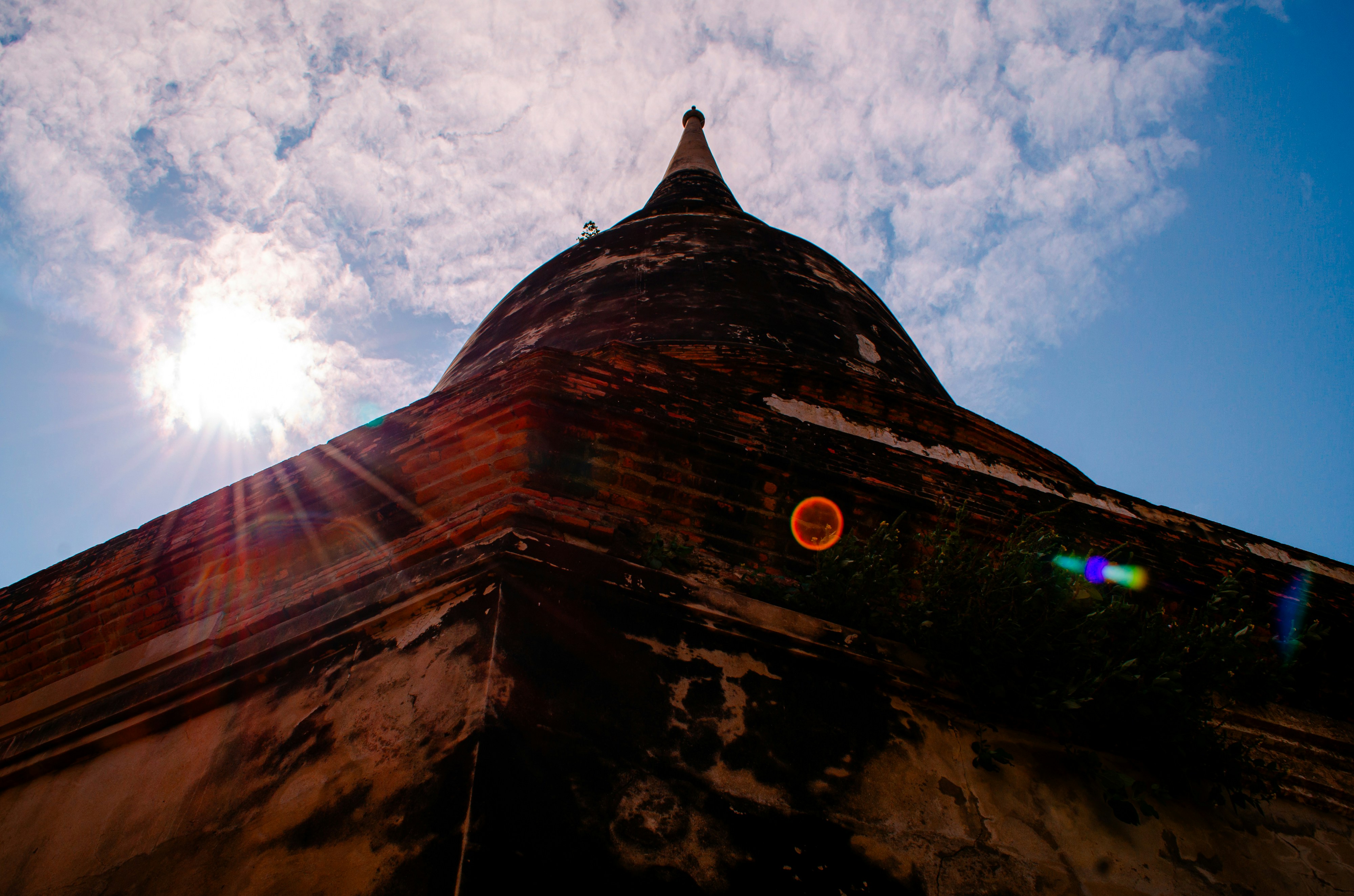 Sunflare over the Ancient Spire: A Low-Angle Gaze Upward